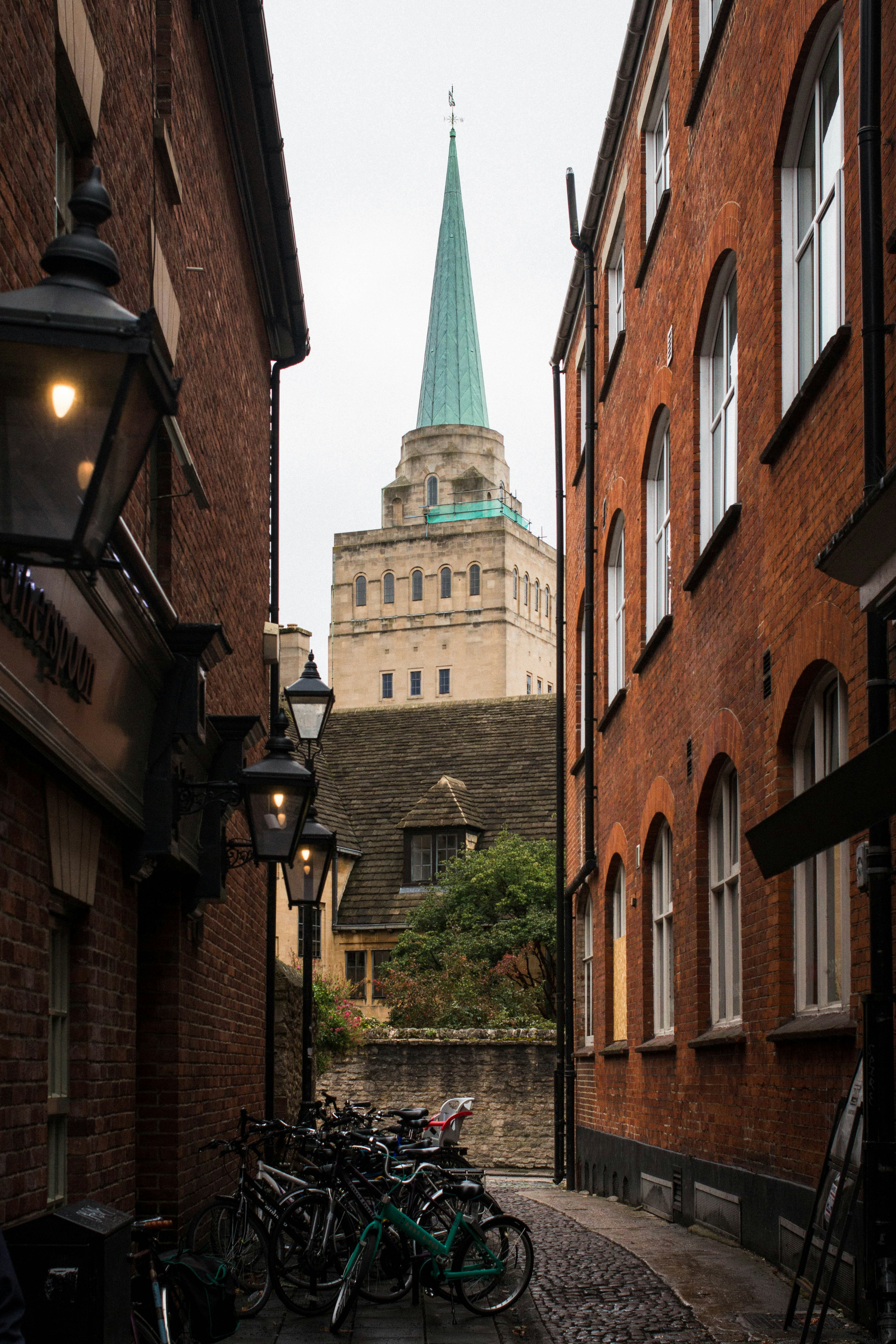 Concrete building with pointed tower between brick buildings photo ...