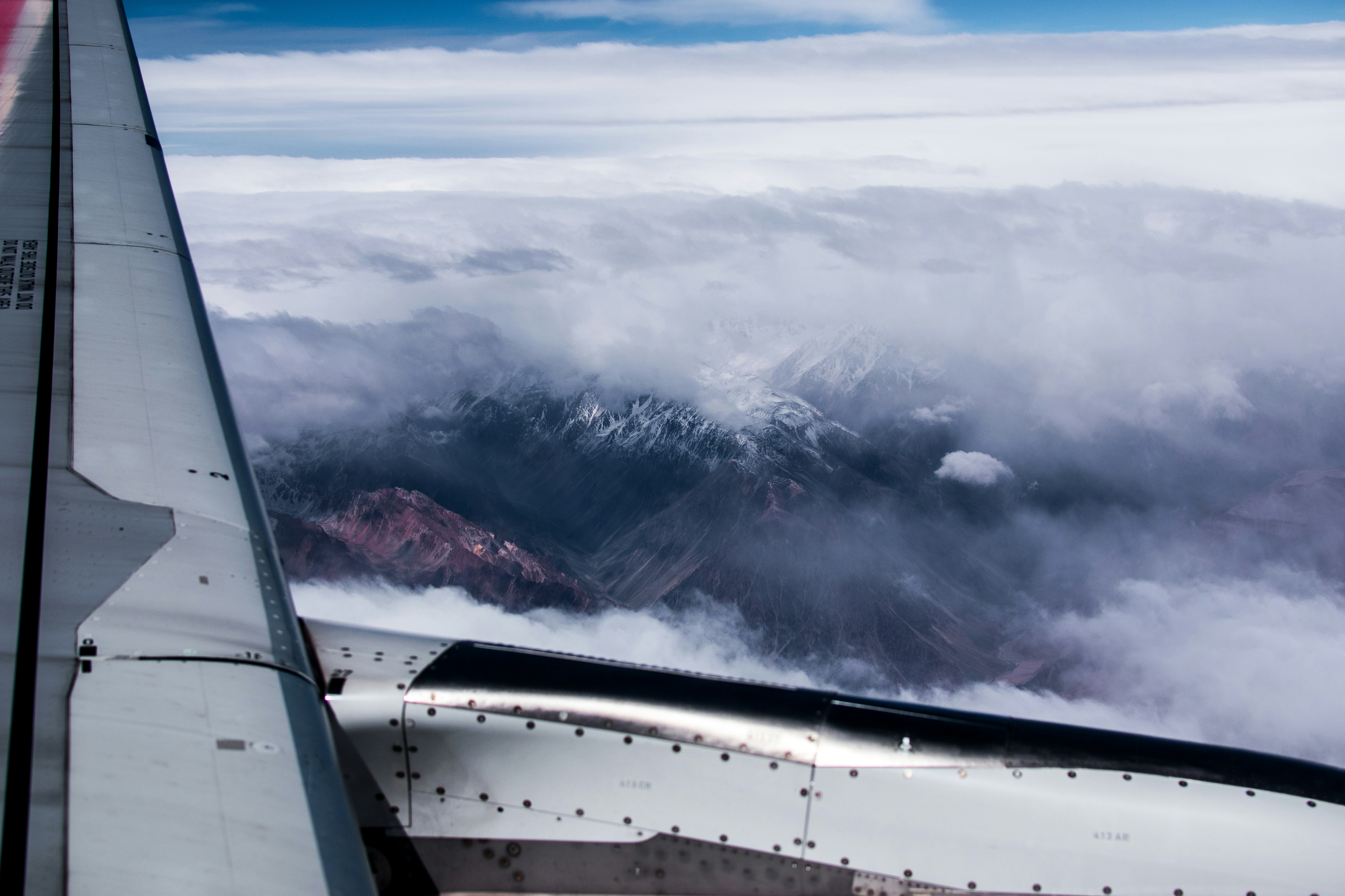 L’aile d’un avion survolant une chaîne de montagnes photo – Image ...
