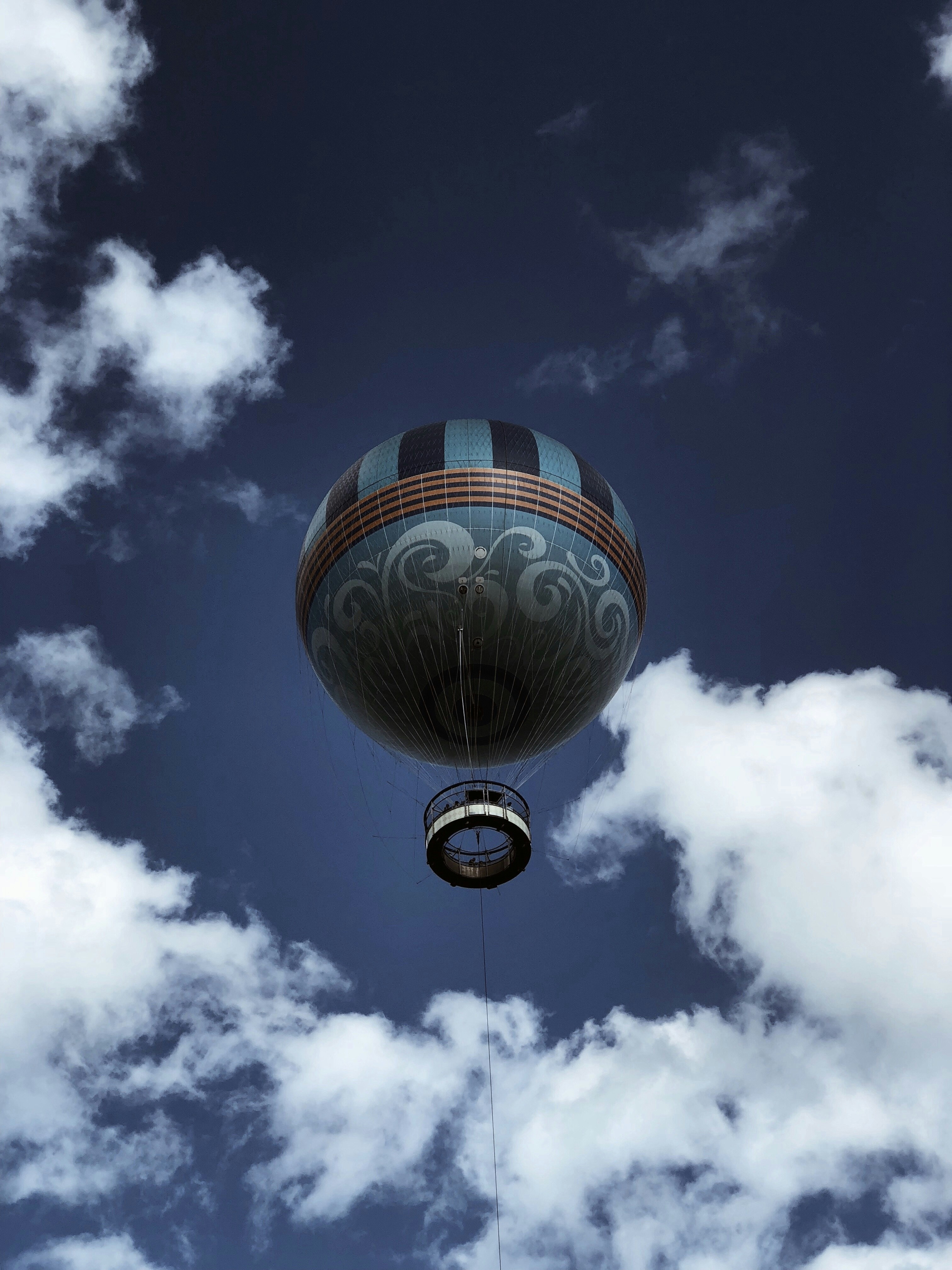 Skybound Orb: An Ornate Blue Balloon Drifts Across a Clear Day