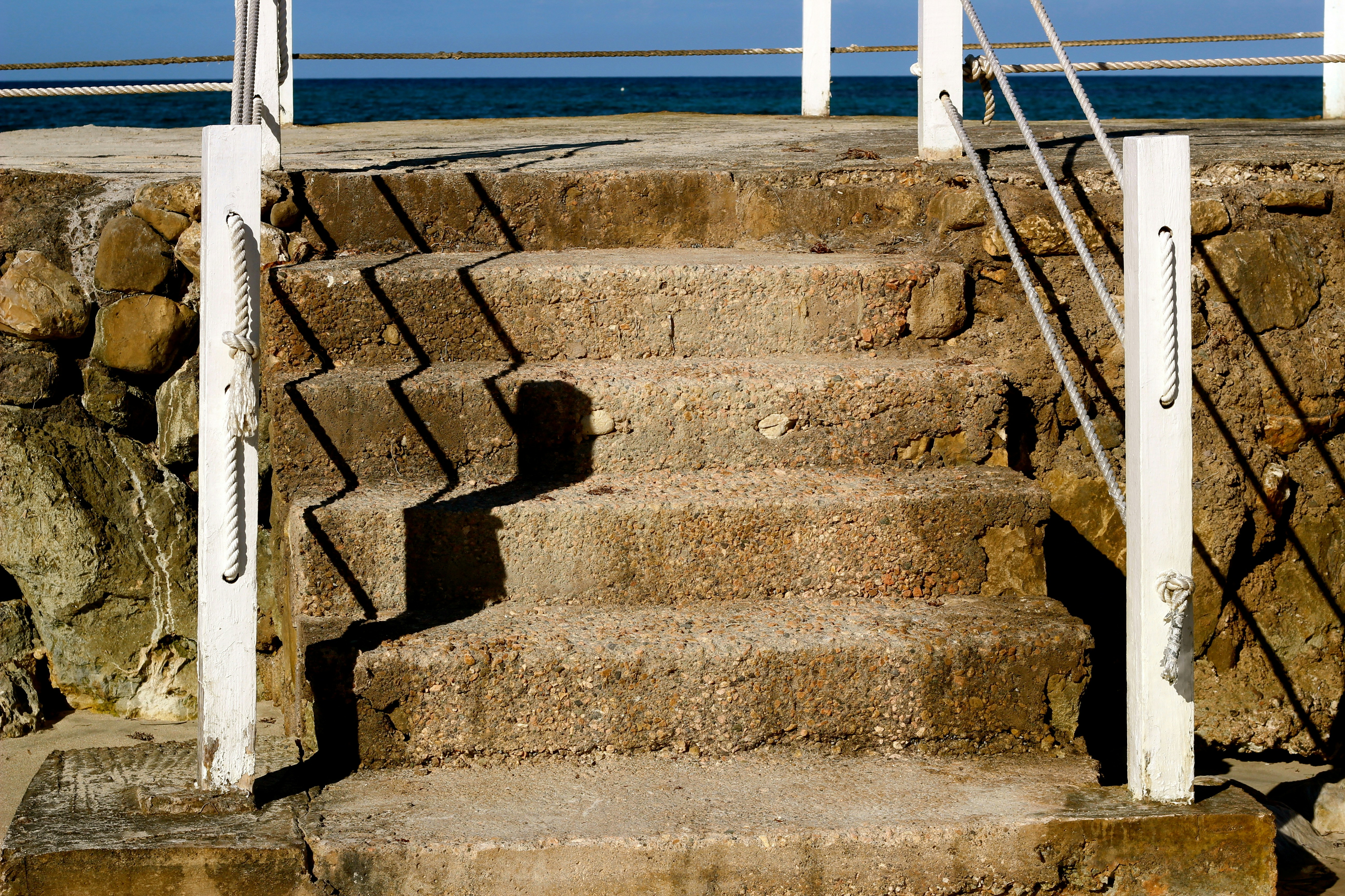 Rugged Staircase to the Sea: Weathered Concrete Framing the Blue Horizon