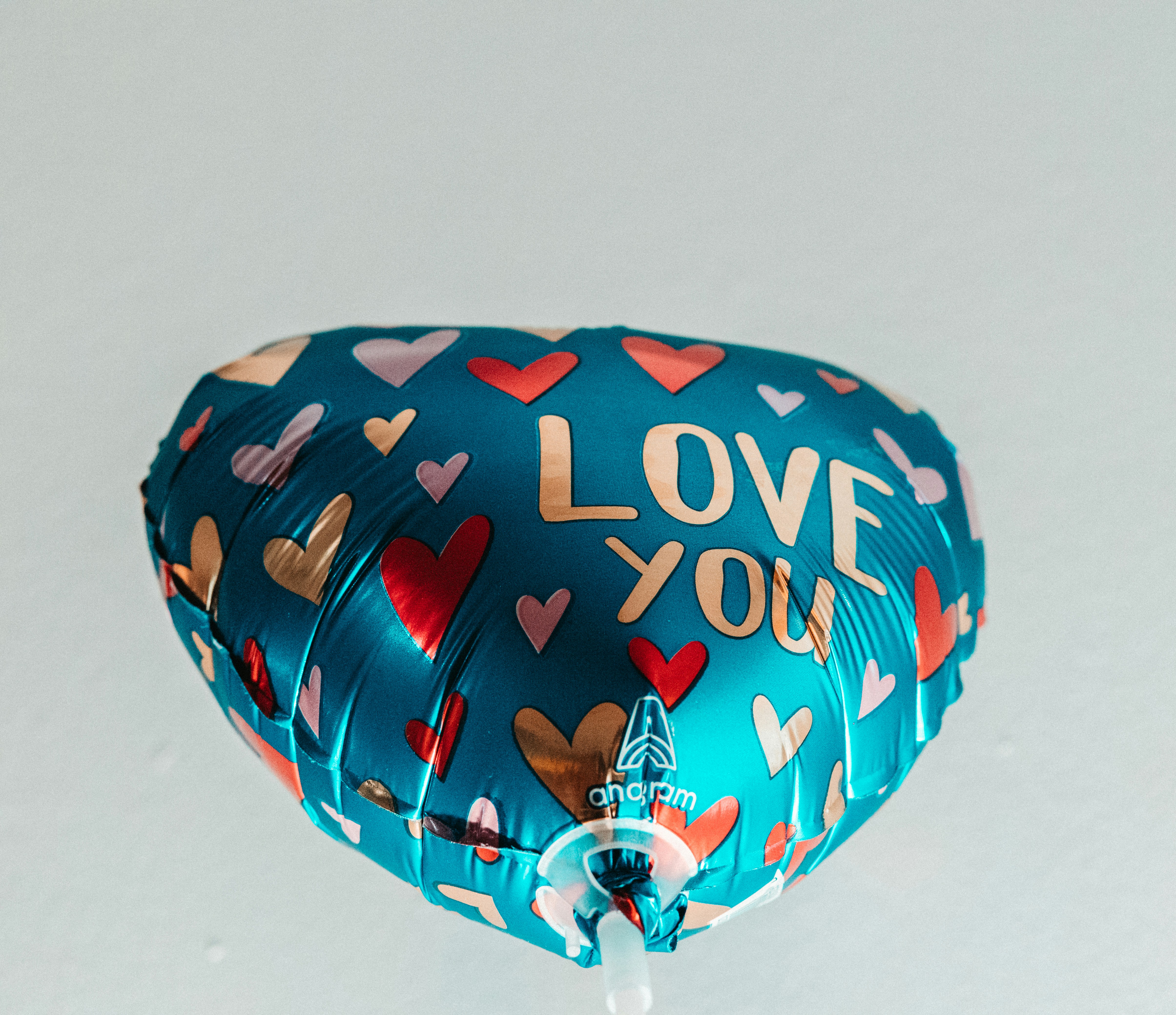 Heartfelt Helium: A Love Balloon Hovering Against a Soft Ceiling