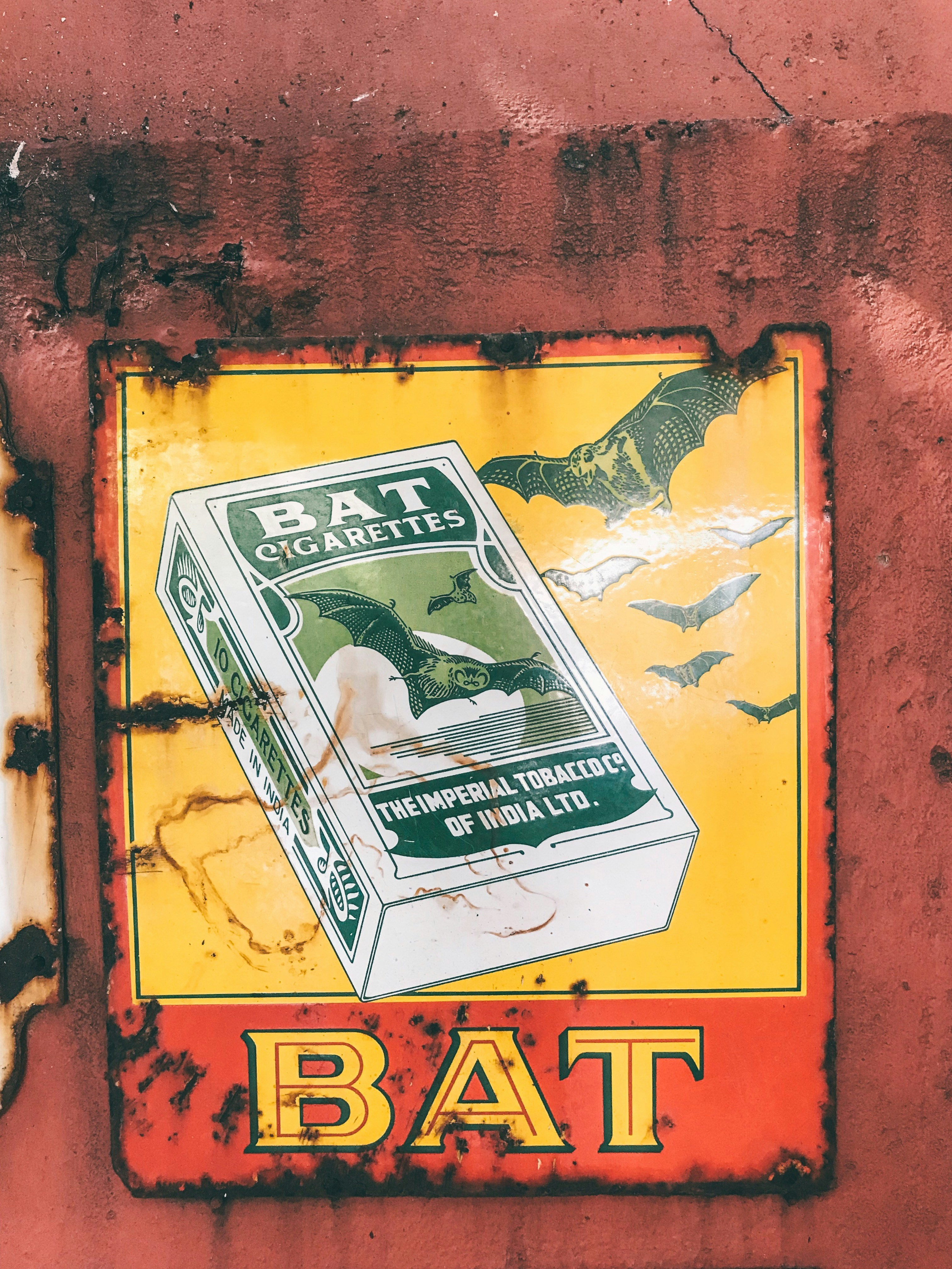 Bat Cigarettes poster on red wall photo – Free Animal Image on Unsplash