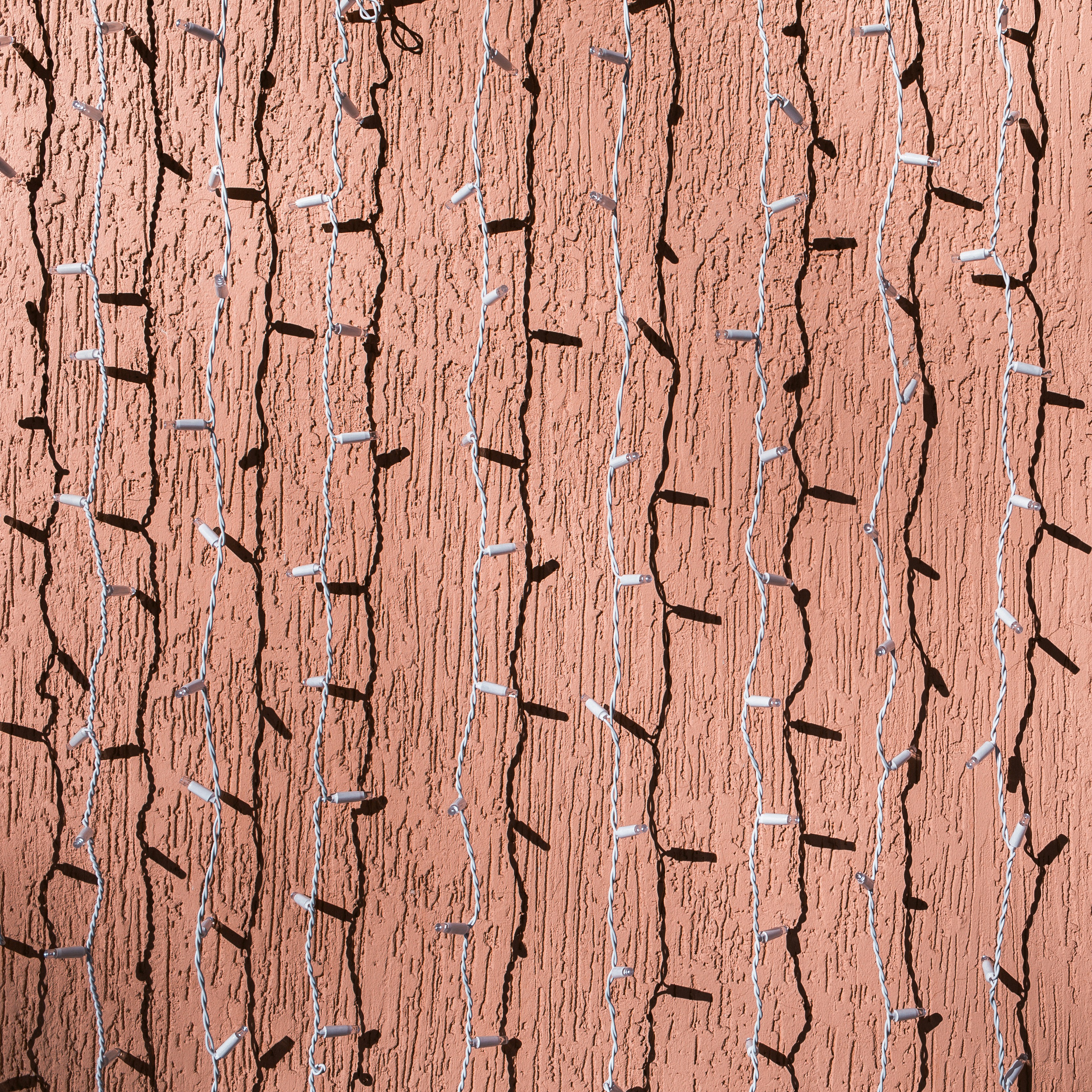 Cracked Pink Facade: Vertical Grout Veins in a Textural Close-Up