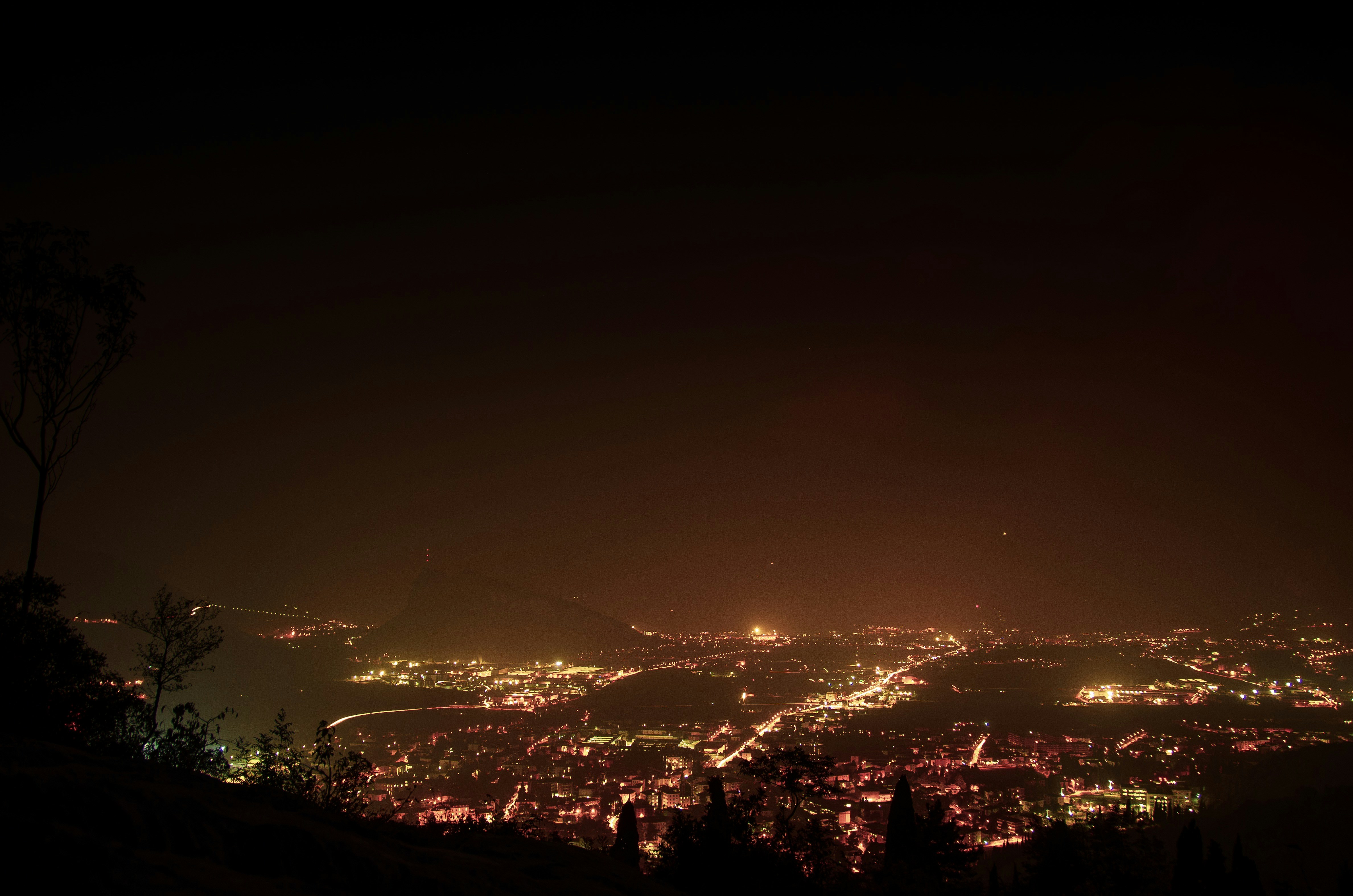 City lights twinkle under a dark sky, creating a vibrant urban landscape at night.