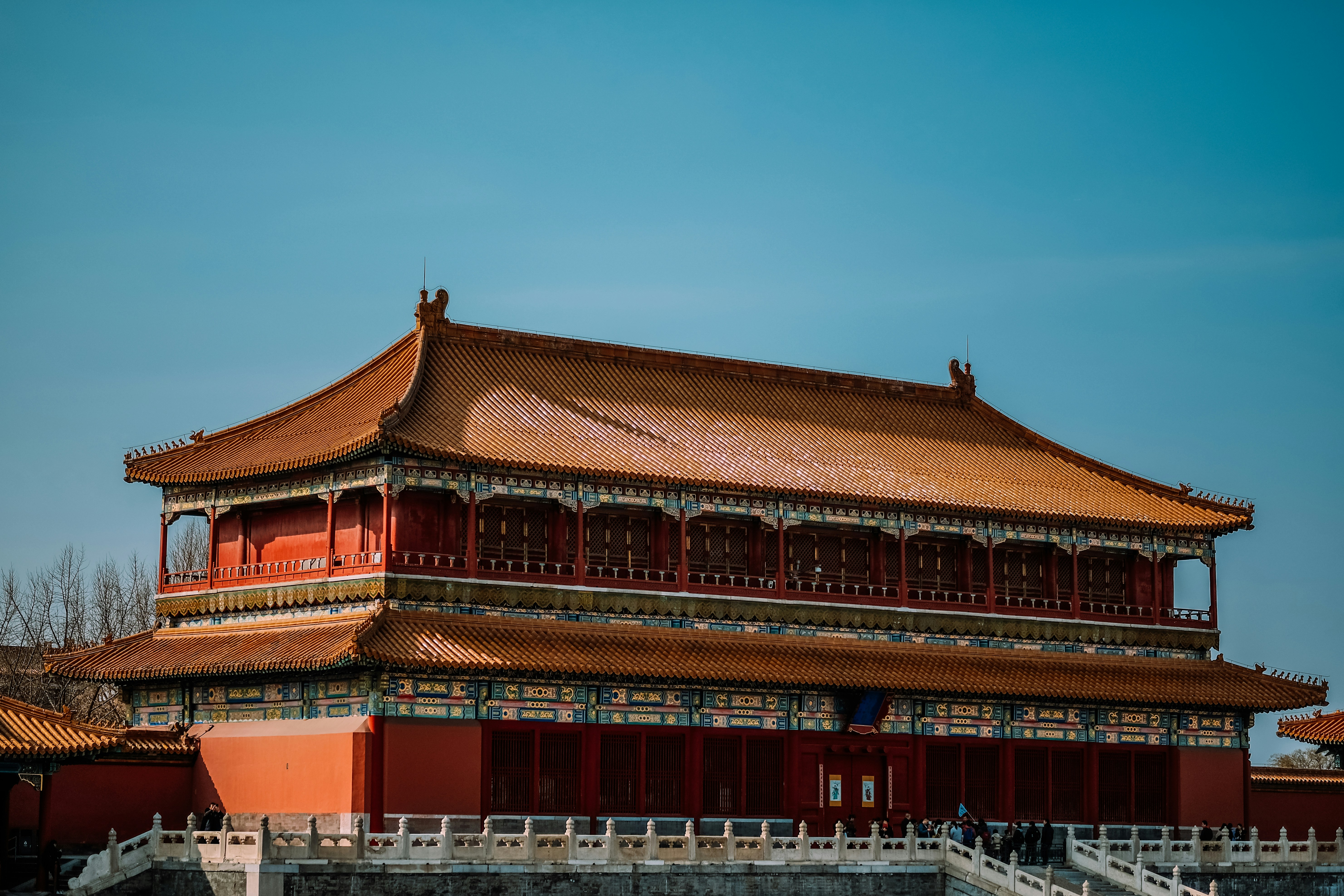 Intricate traditional Chinese architecture featuring a golden roof and vibrant colors against a clear blue sky.