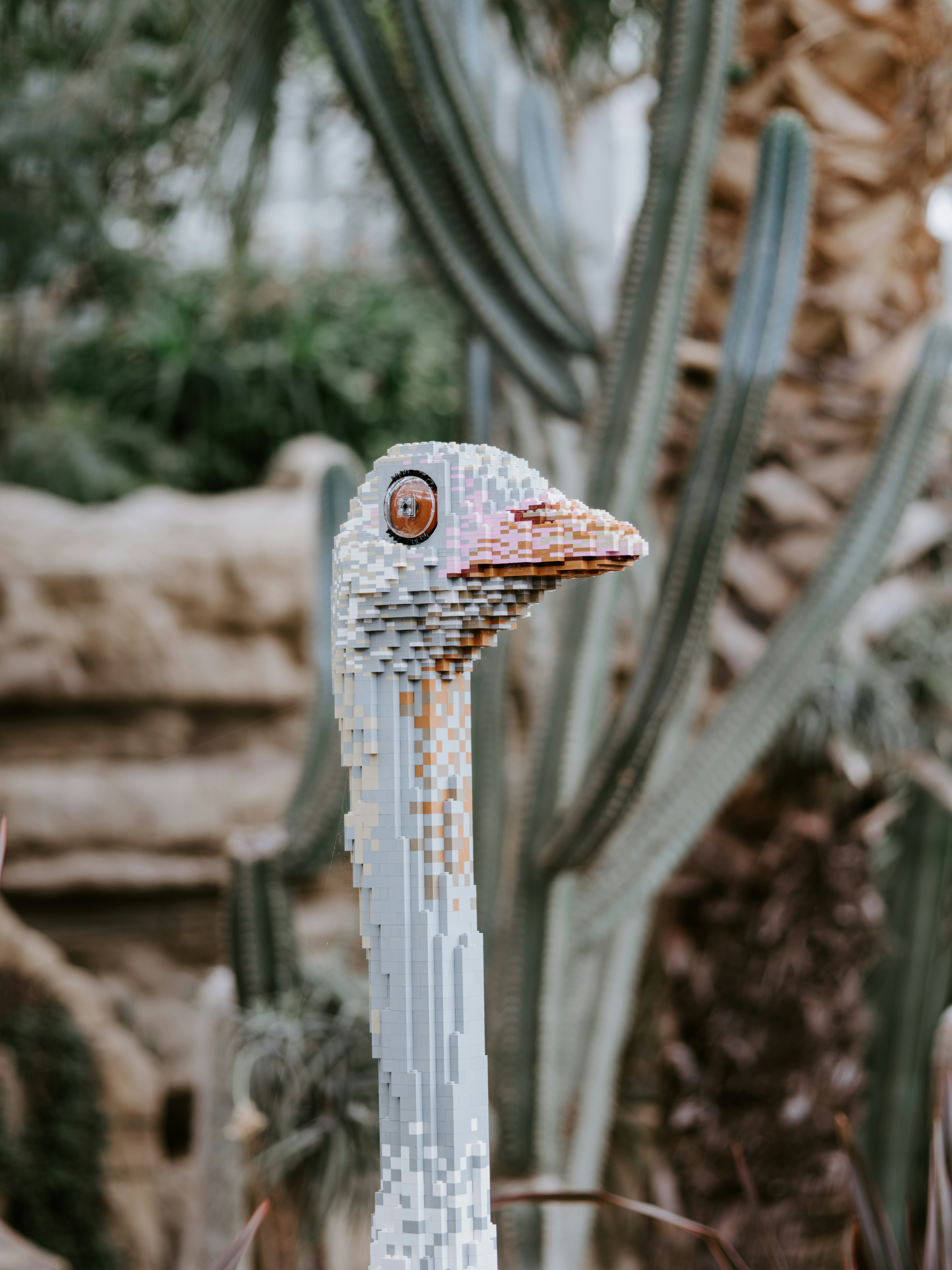 Pixelated Heron: A LEGO Giraffe-Headed Crane in a Desert Garden