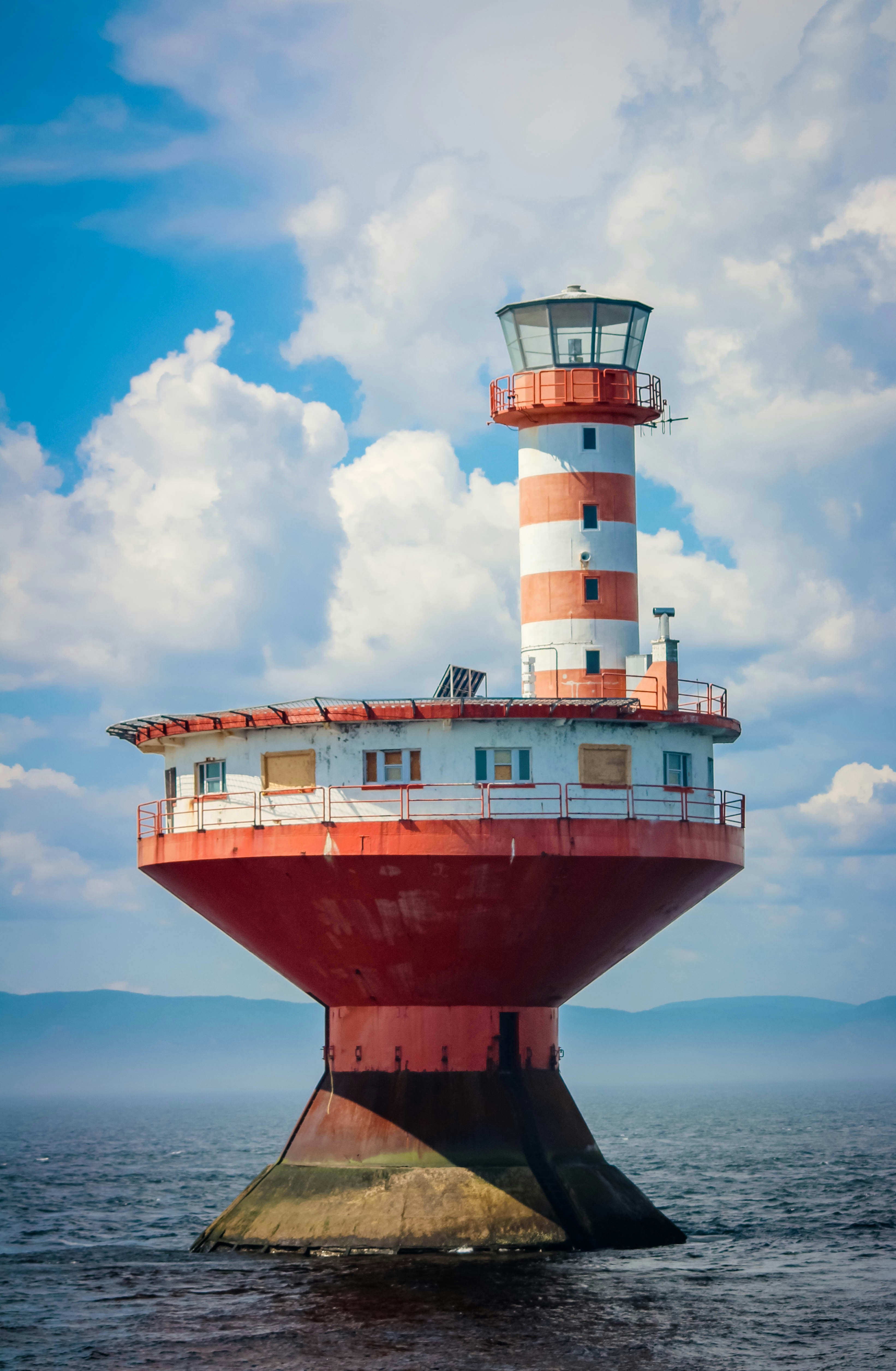 Beacon Rising from the Sea: A Red-and-White Lighthouse Structure