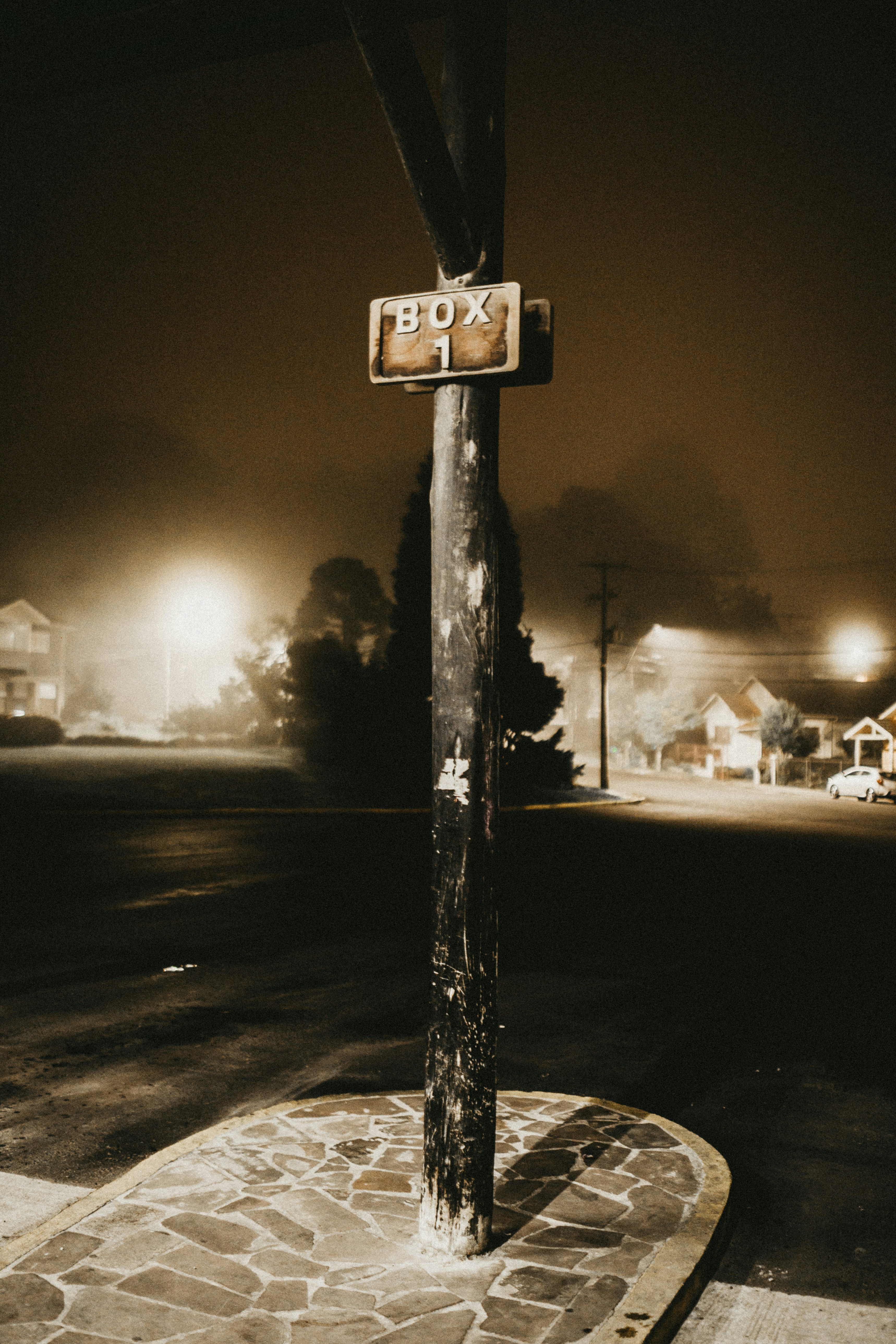 Box 1 on a Weathered Pole Under Amber Night Streetlights