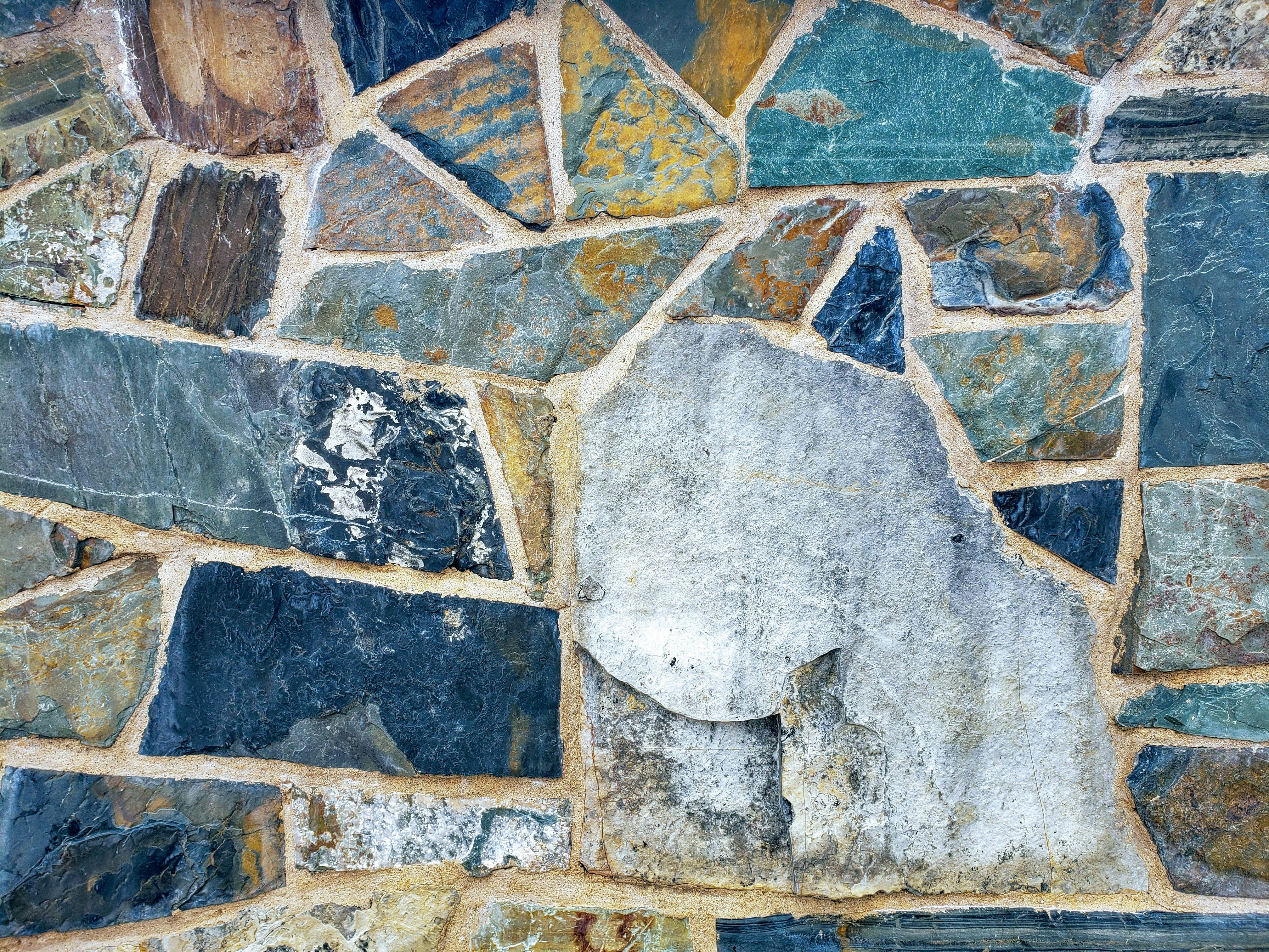 A textured arrangement of various stones showcasing a blend of colors and patterns, highlighting the beauty of natural materials in architecture.
