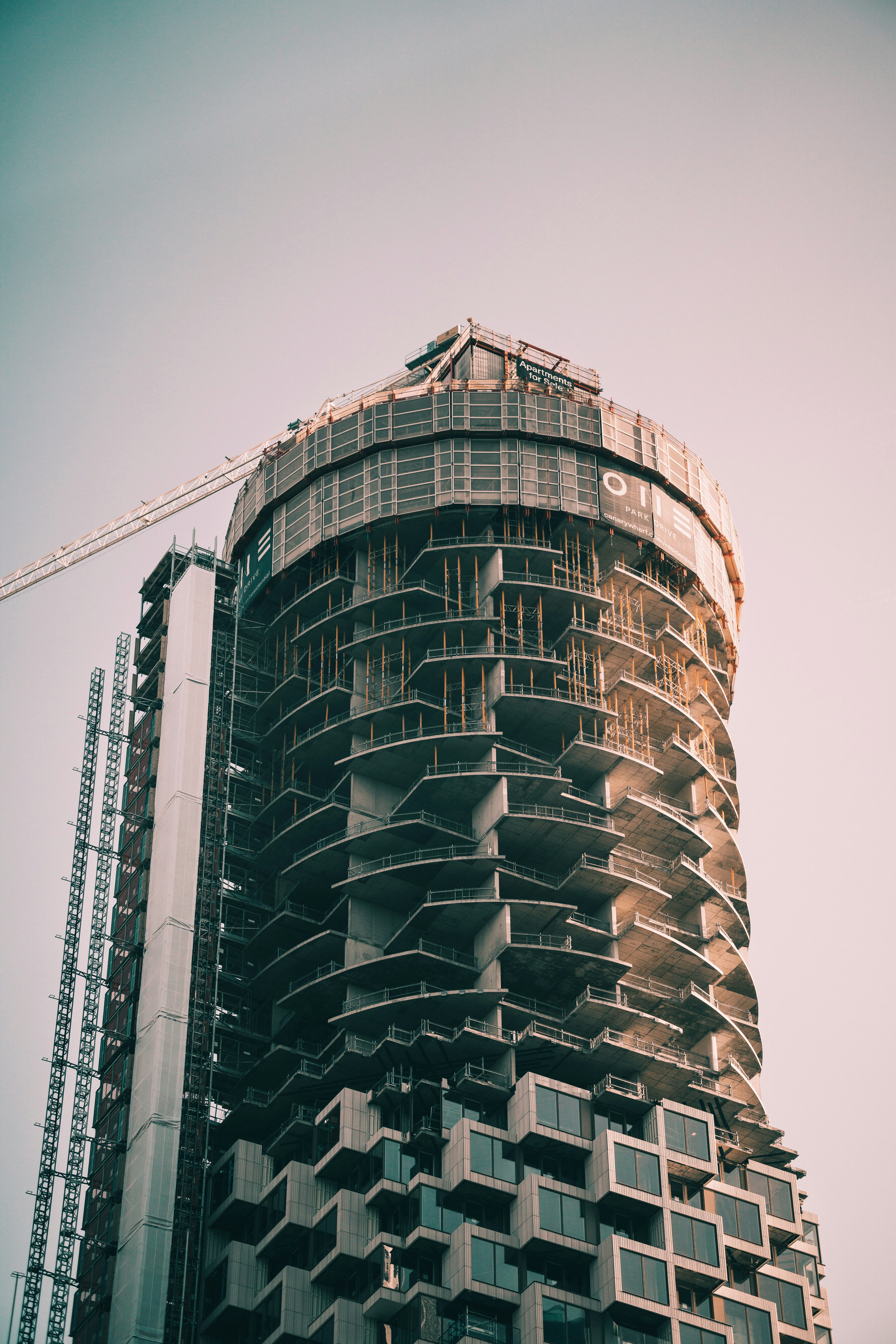 Modern skyscraper under construction with a distinctive spiral design and scaffolding, showcasing architectural innovation.