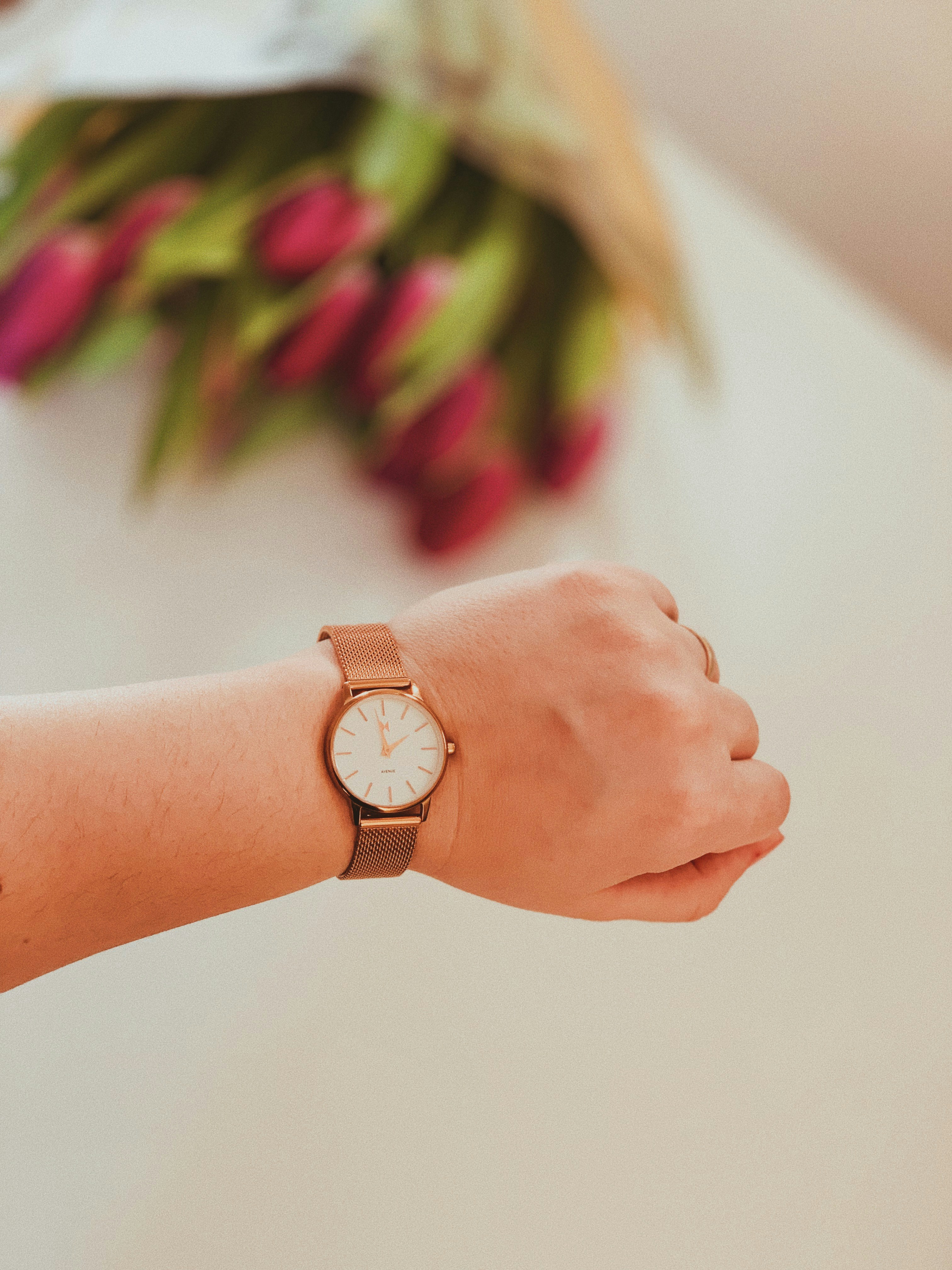 person wearing round gold-colored framed analog watch
