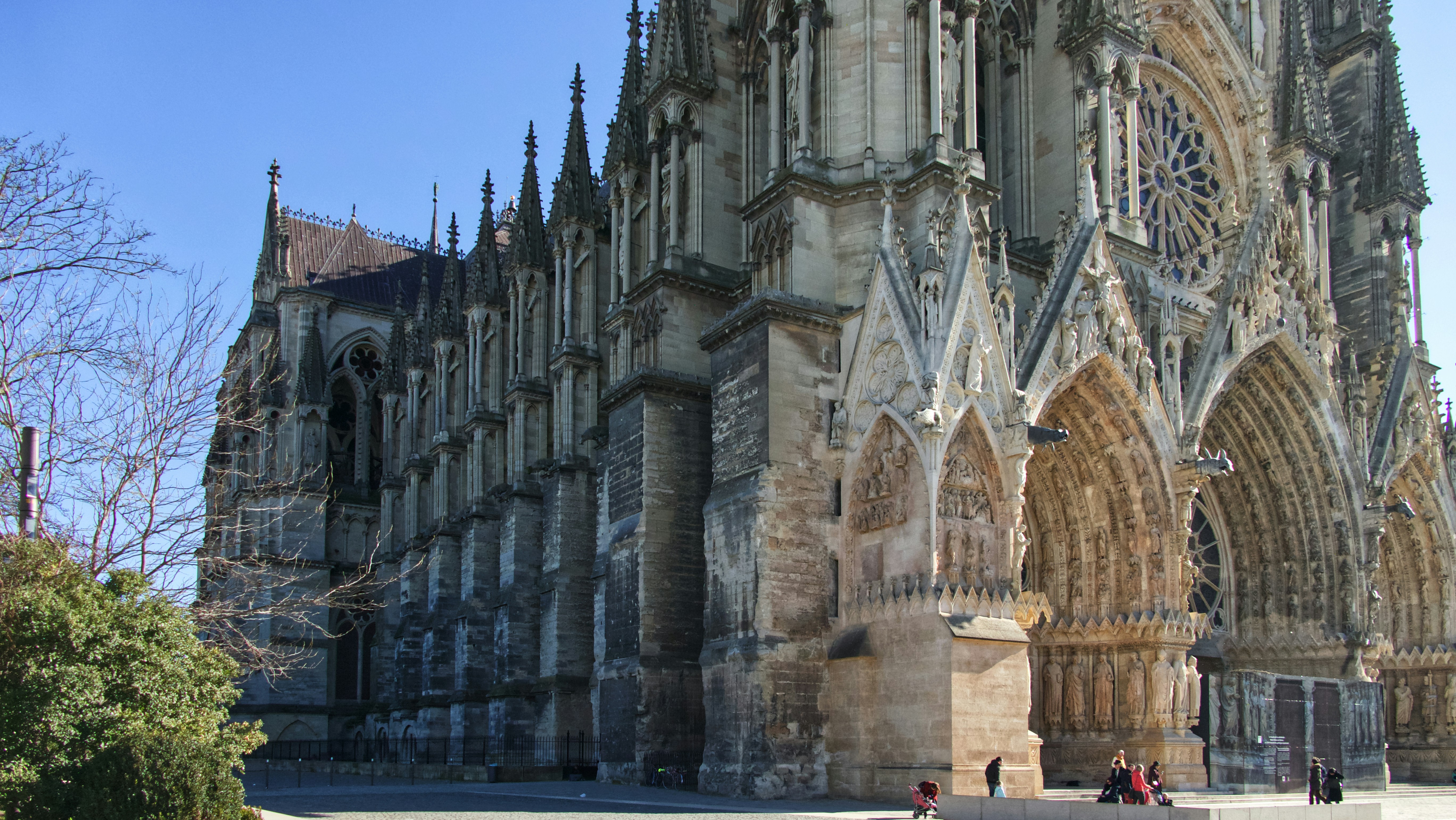 Grand cathedral facade with intricate stonework against a clear blue sky.