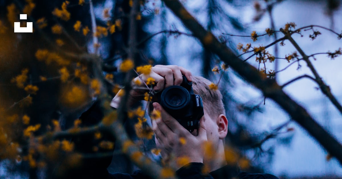 캐논 Dslr 카메라를 들고 있는 남자의 선택적 초점 사진 사진 Unsplash의 무료 꽃 이미지