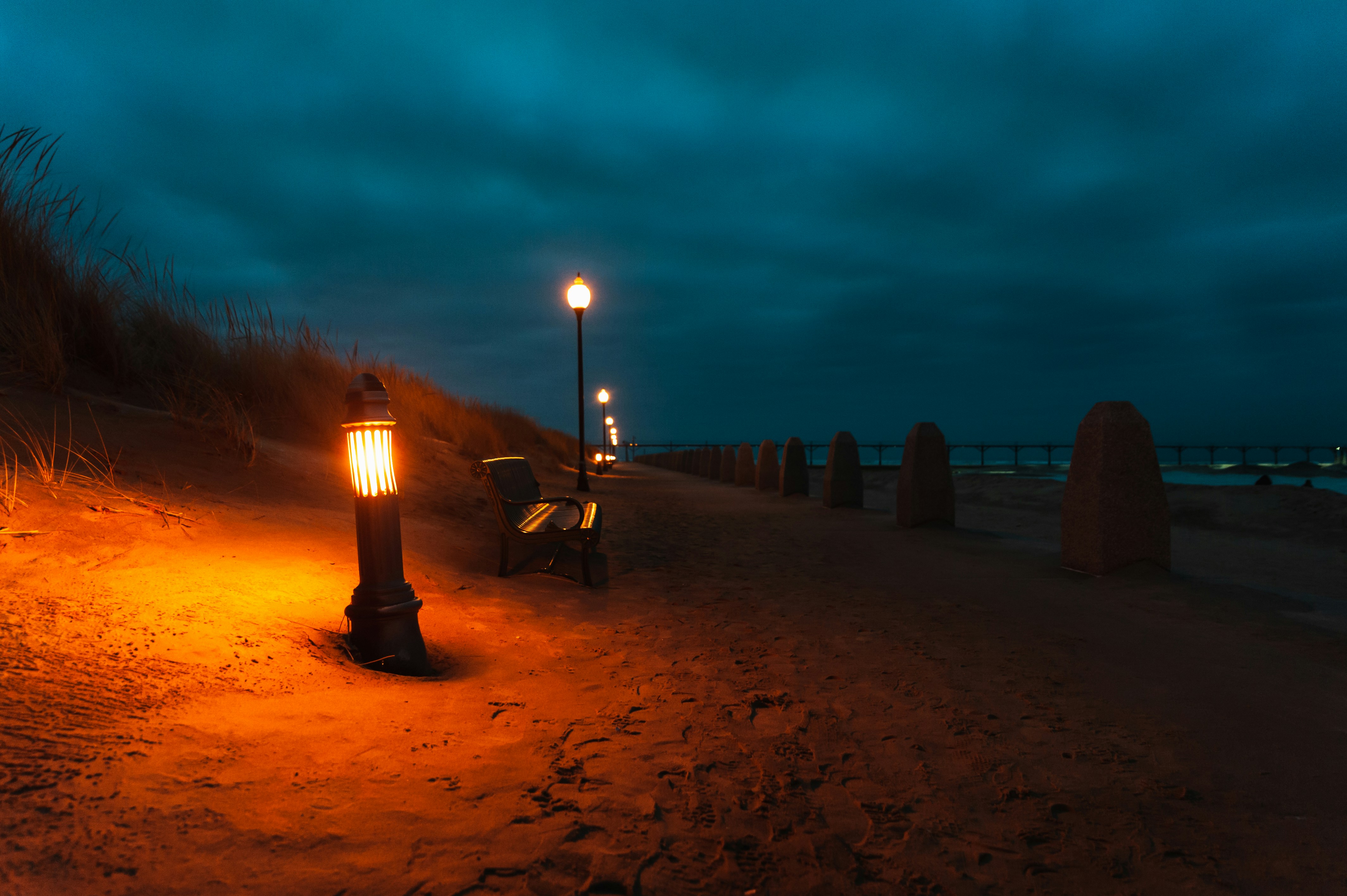 Amber Lanterns along a Duneside Promenade at Blue Hour