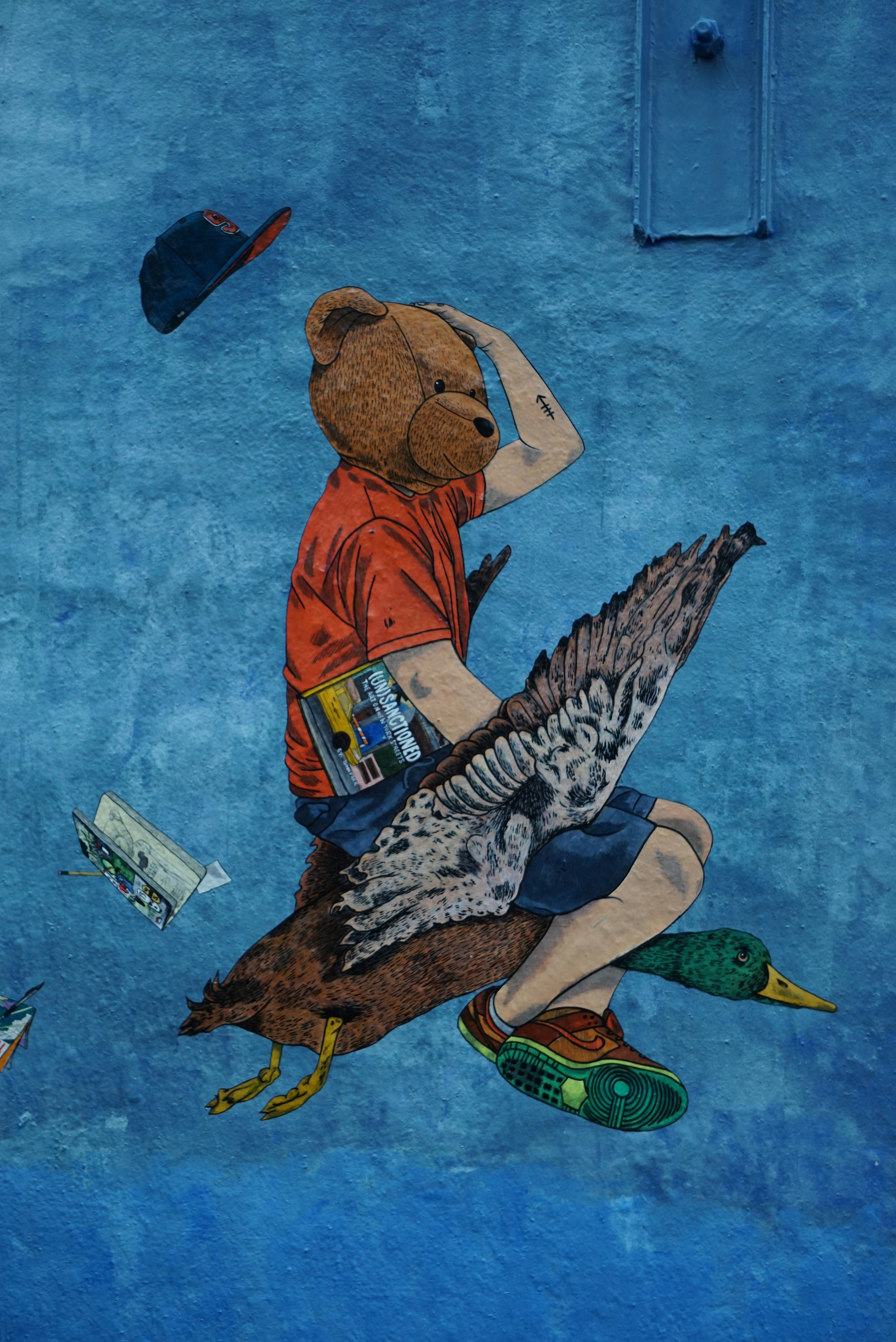 Blue Wall, Brown Bear, and Flying Goose: A Whimsical Street Scene