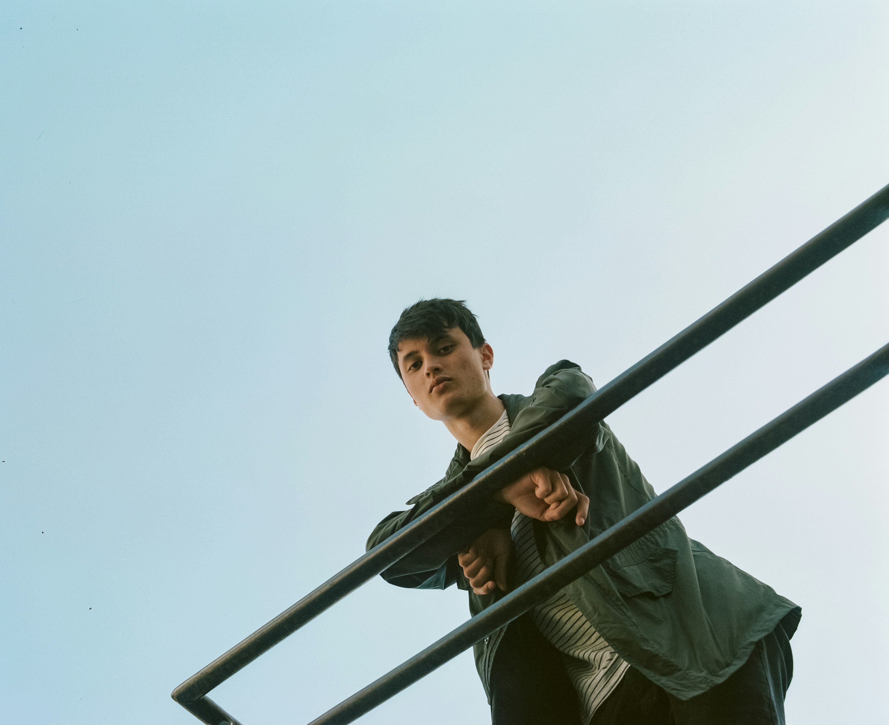 Man in gray jacket standing leaning on rails photo – Free Human Image ...