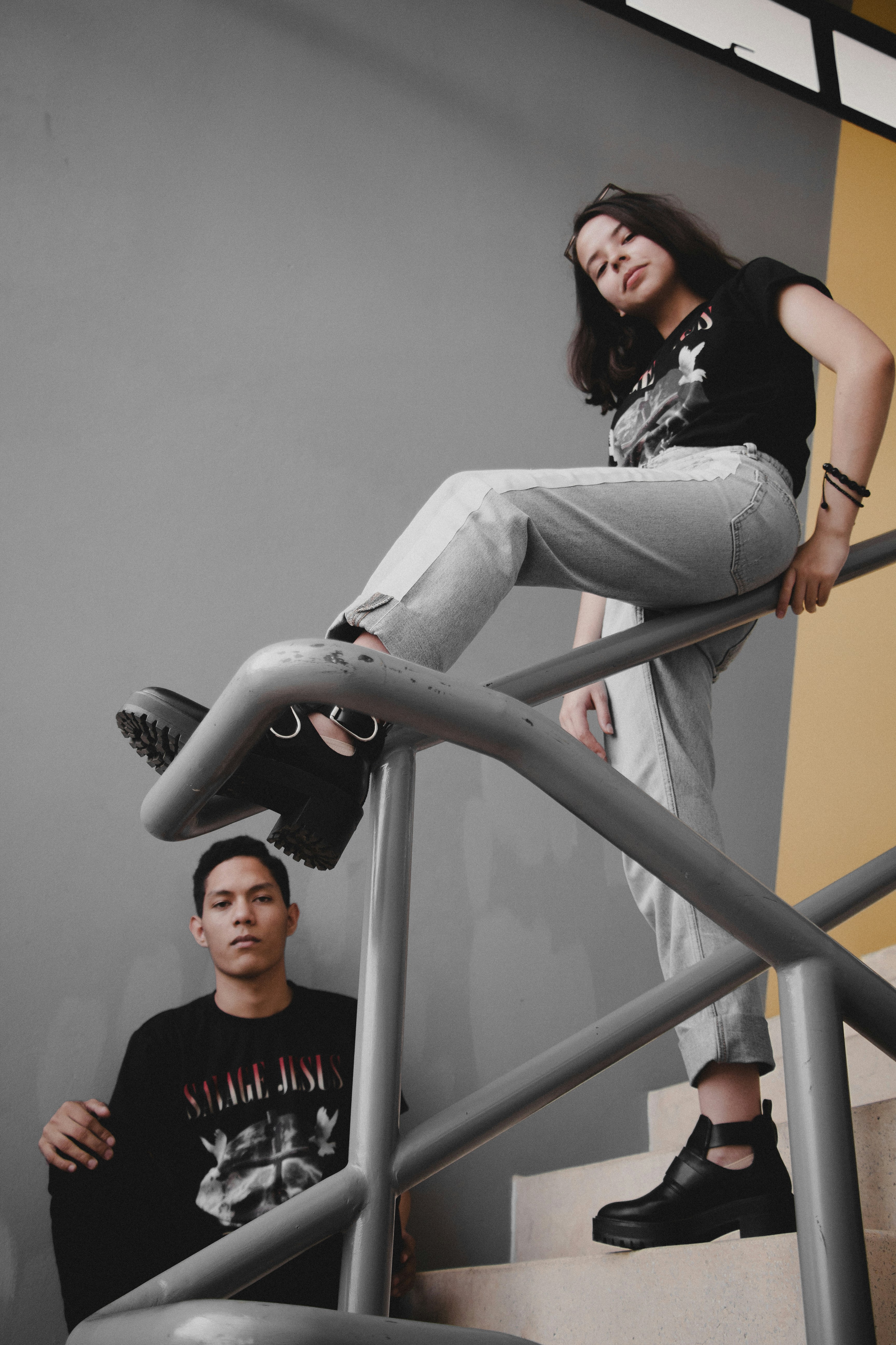 Woman raising left leg along railing with man sitting beside photo ...