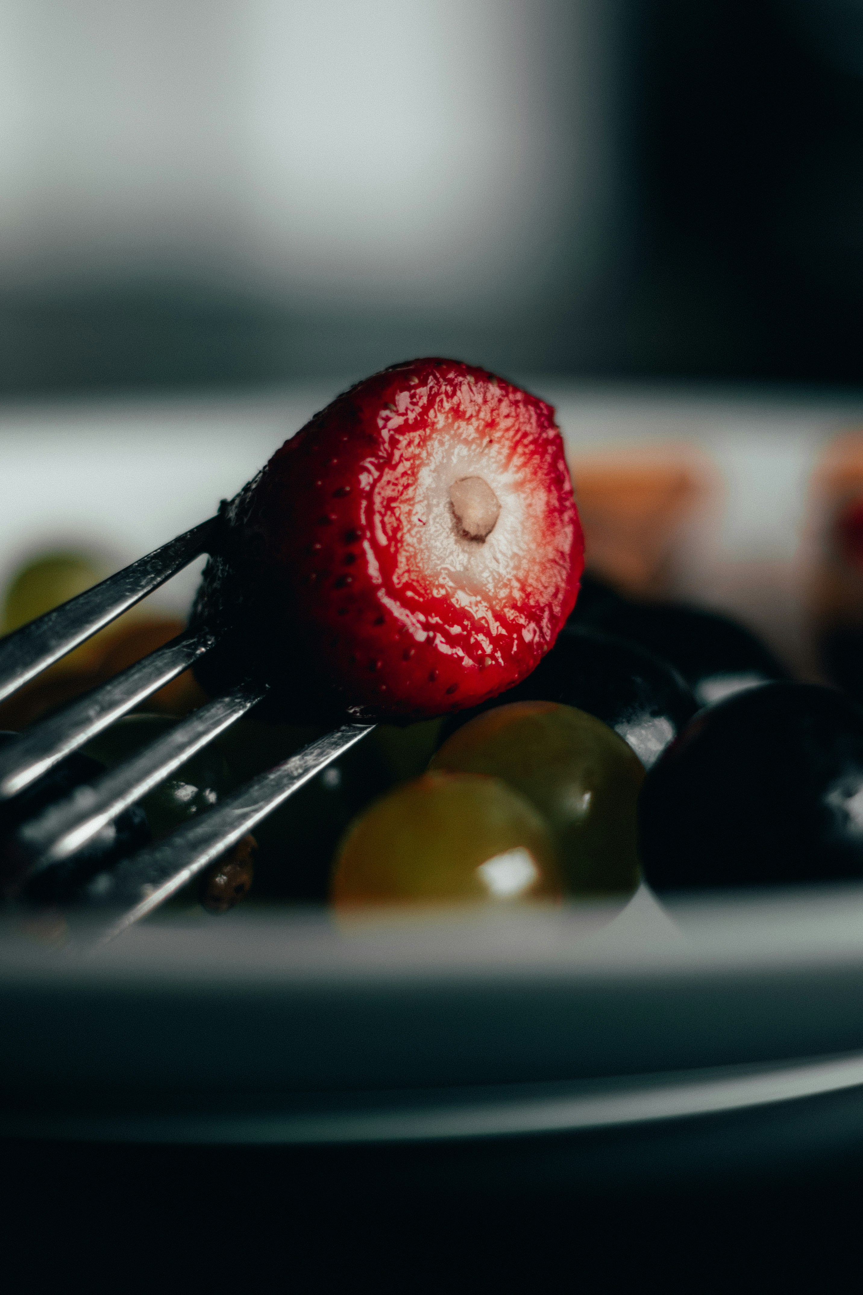Crimson Halo: A Strawberry Gripped by Silver Tines