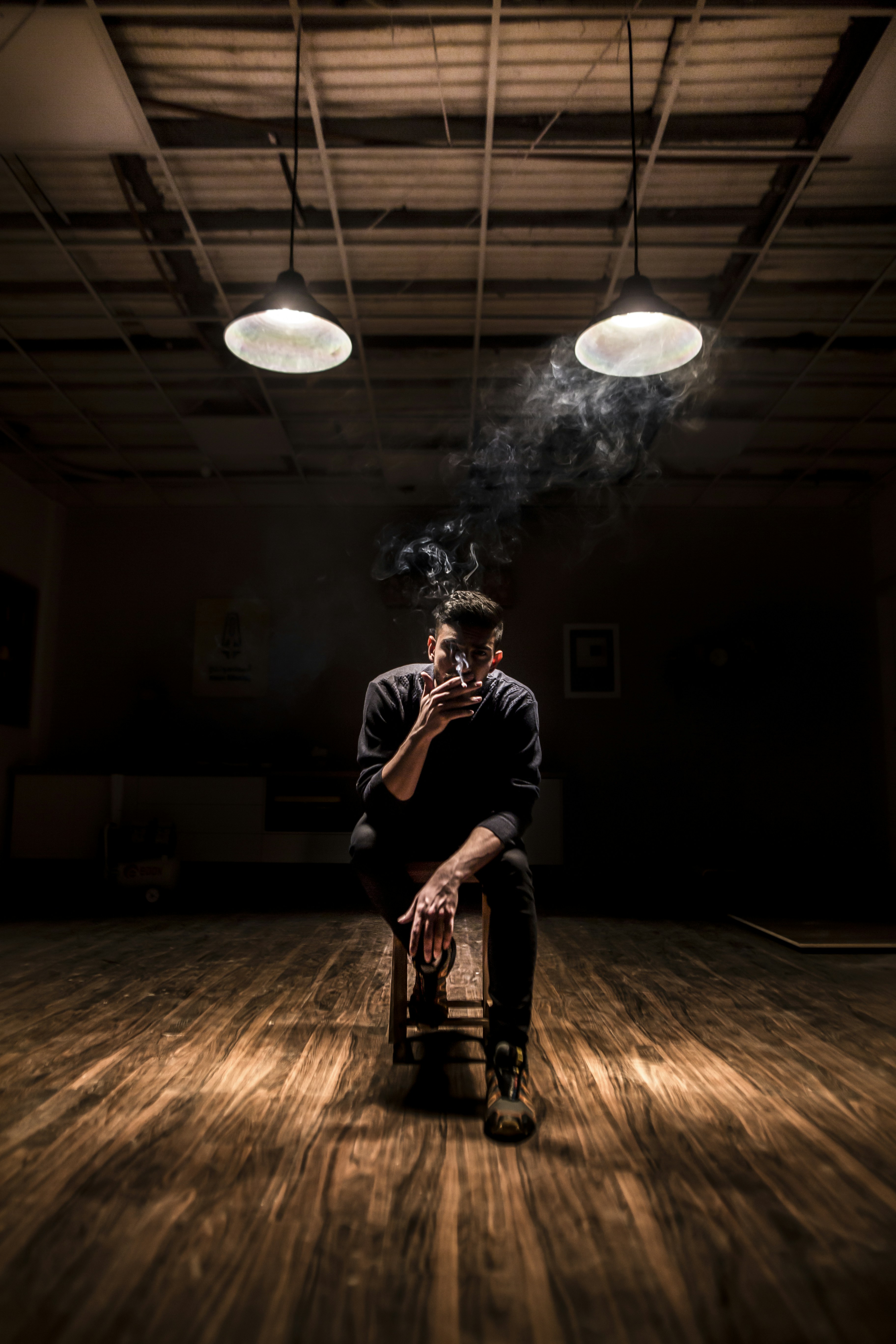 Midnight Studio Solitude: Smoky Portrait Beneath Industrial Pendant Lights