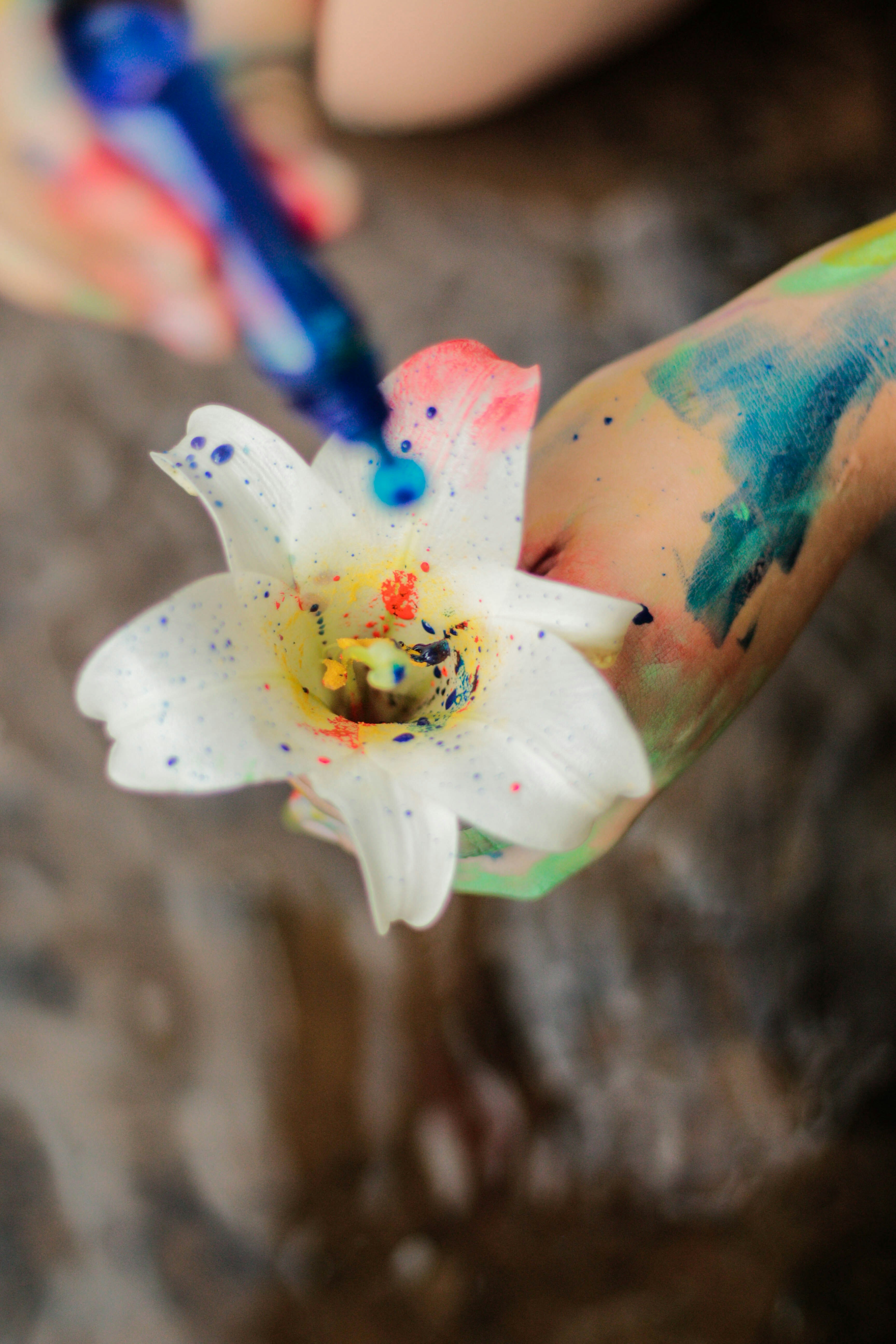 Paint-Splashed Lily Gripped by a Colorful Hand