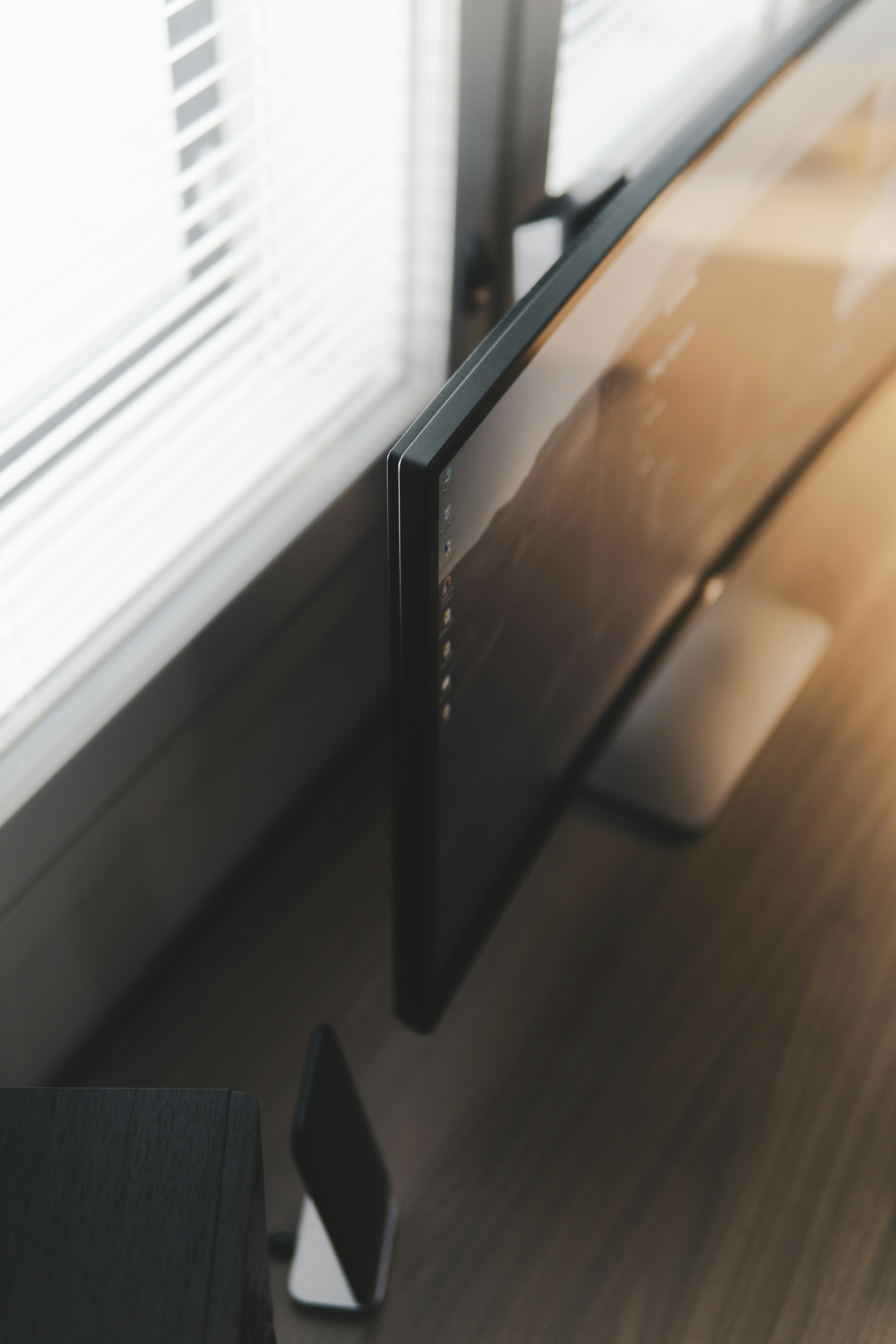 Flat screen computer monitor turned on beside window with Venetian ...