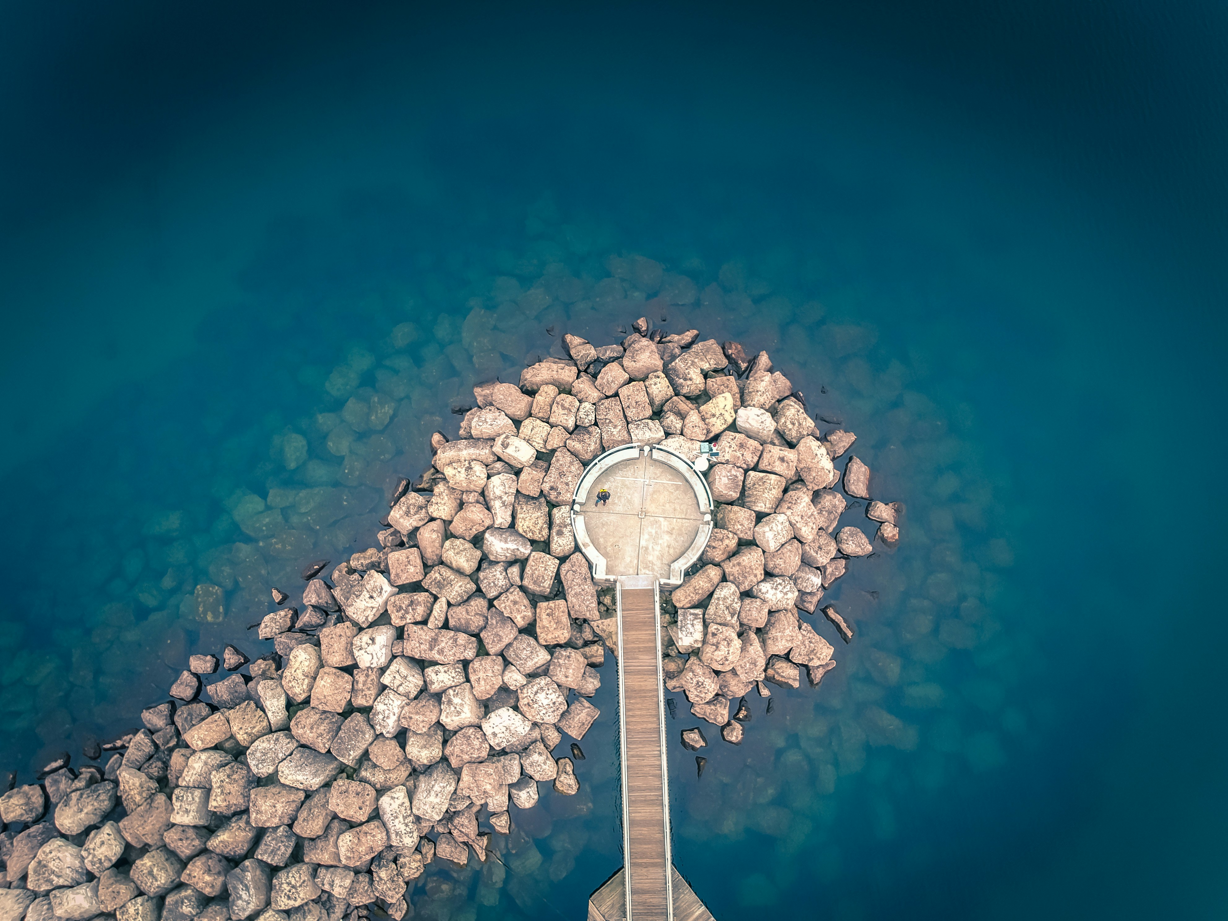 Stone Breakwater Reaching into Cerulean Depths