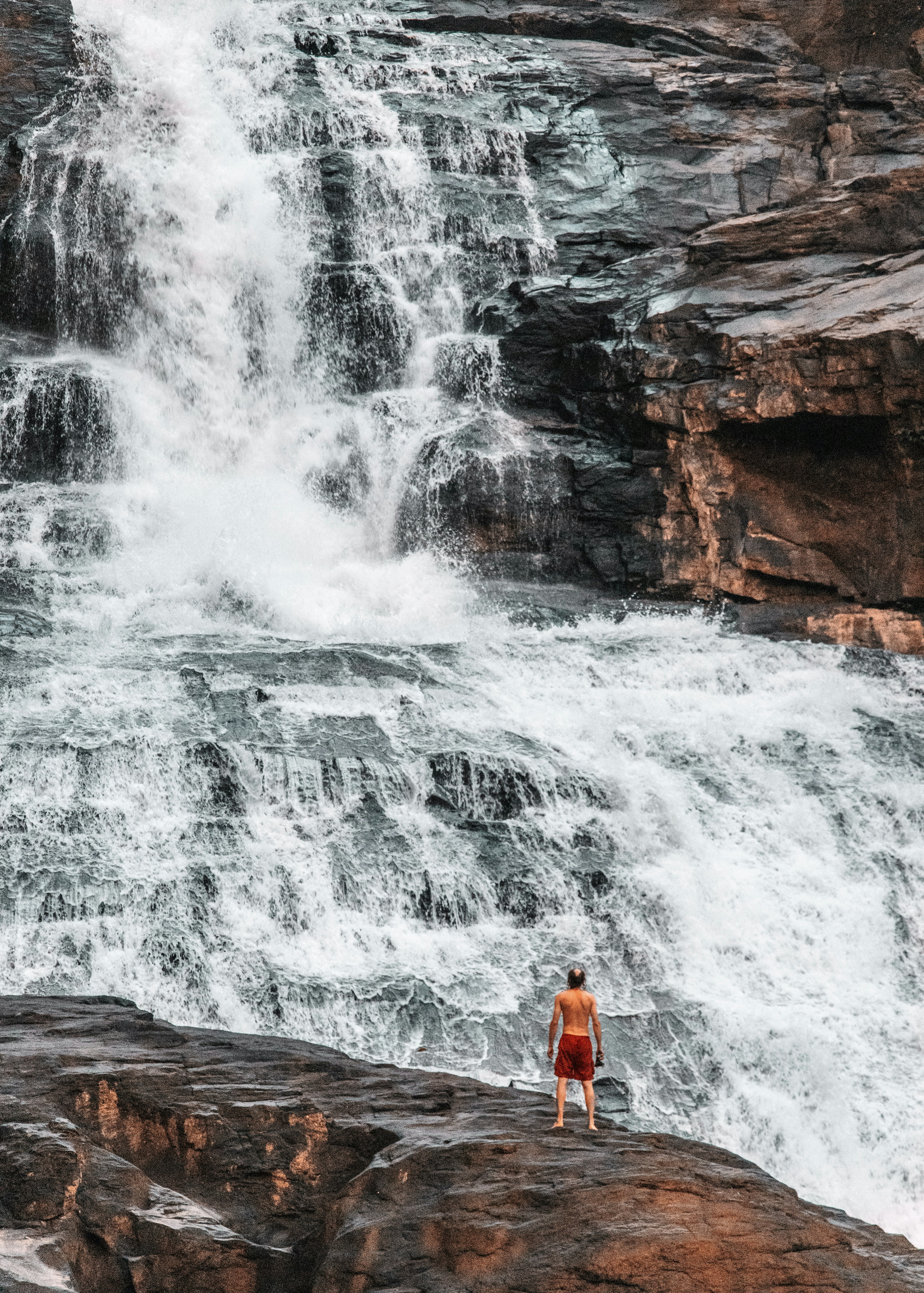 Man standing infront of large waterfall photo – Free Grey Image on Unsplash