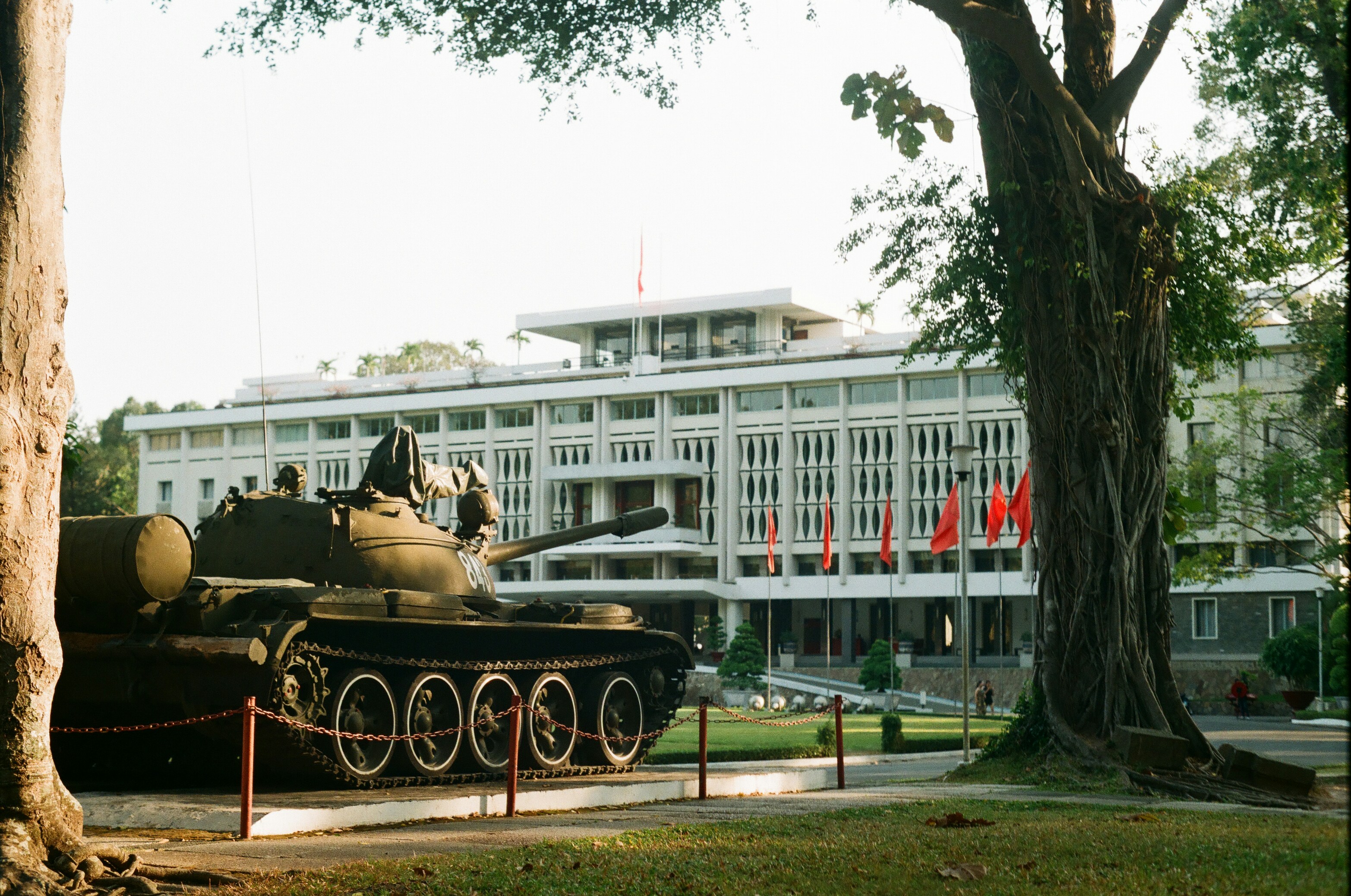 Battle tank beside trees in front of white building photo – Free Grey ...