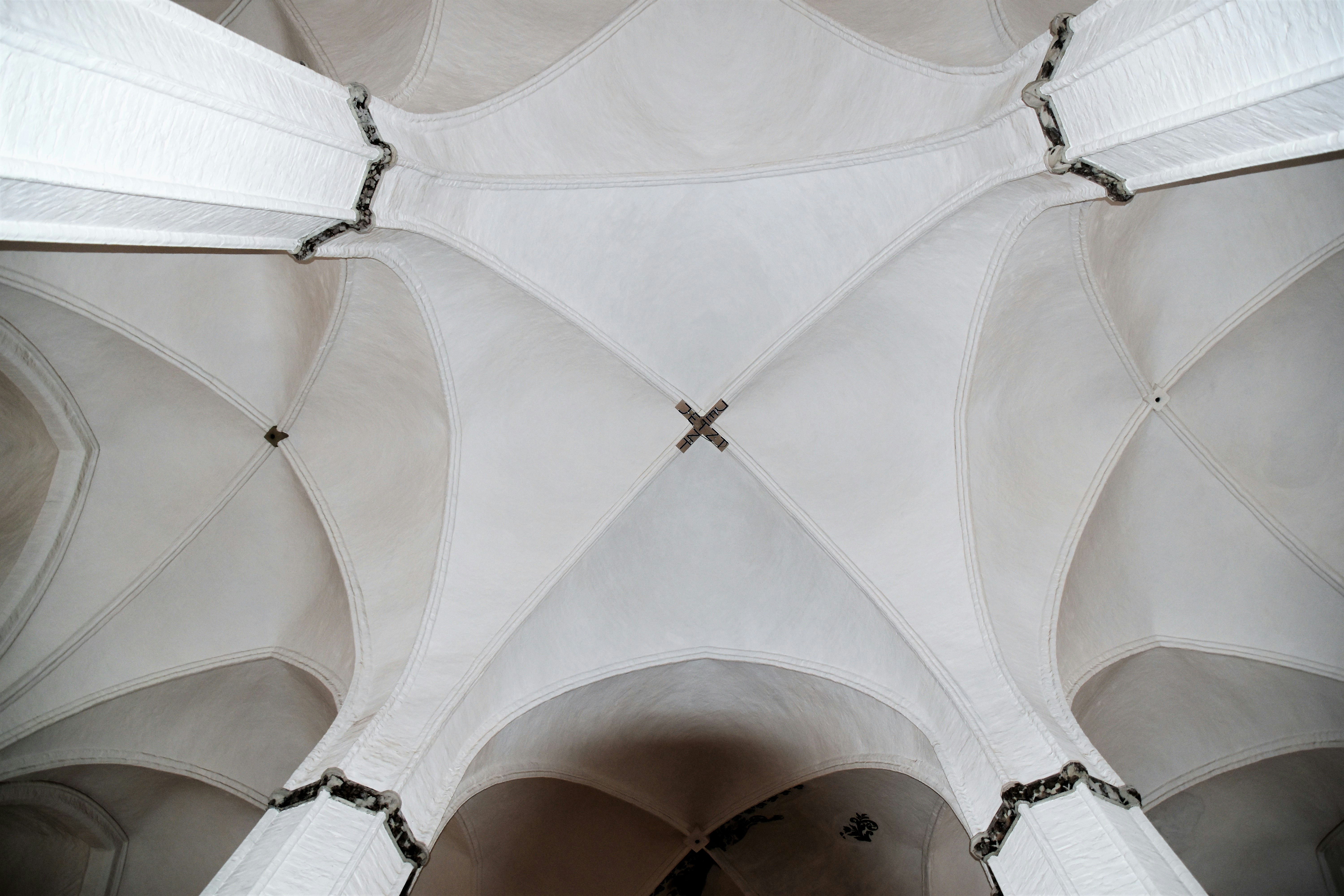 Intricate vaulted ceiling showcasing a network of arches and beams in a historic structure.