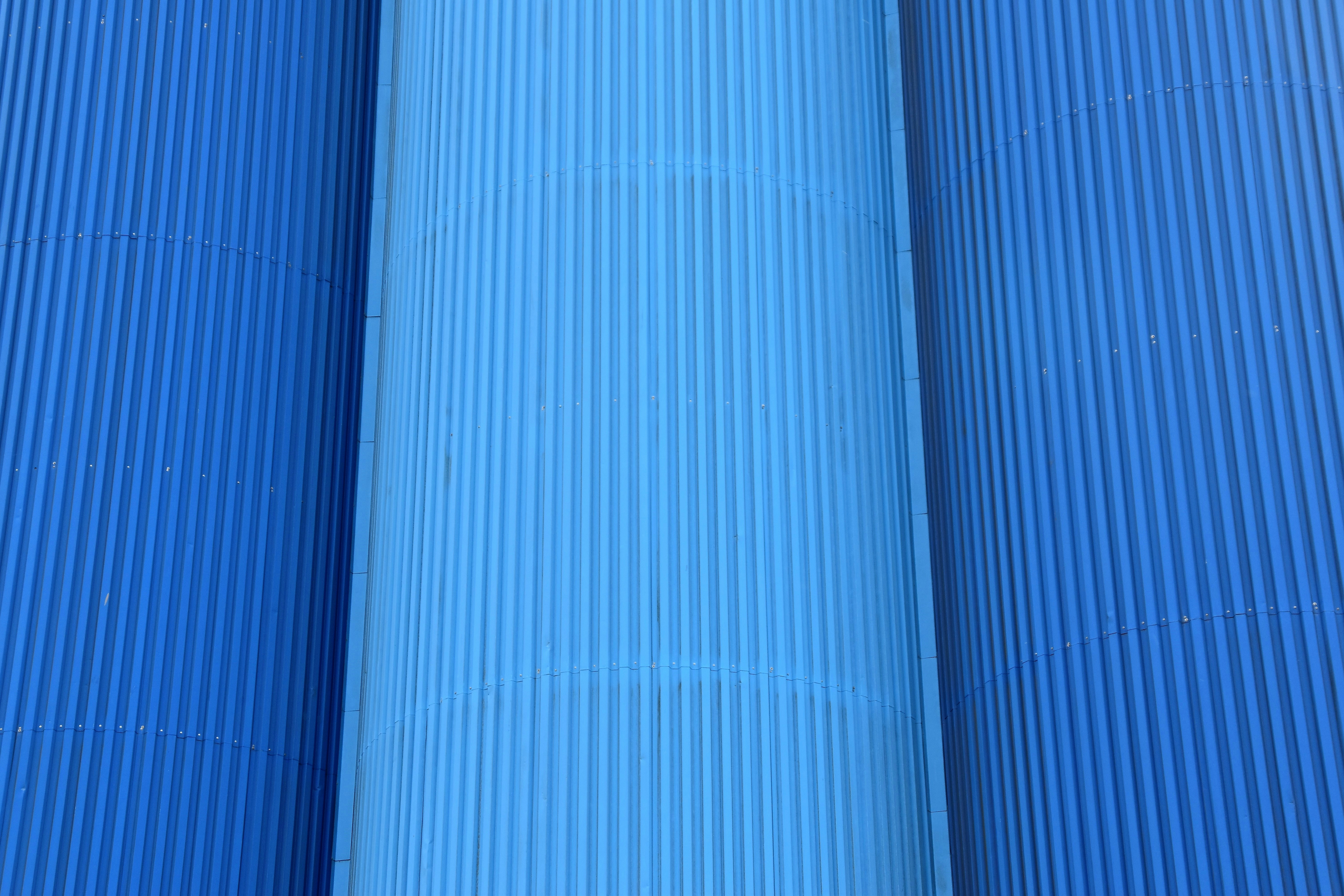Midday Blues: Vertical Corrugations on a Blue Metal Facade