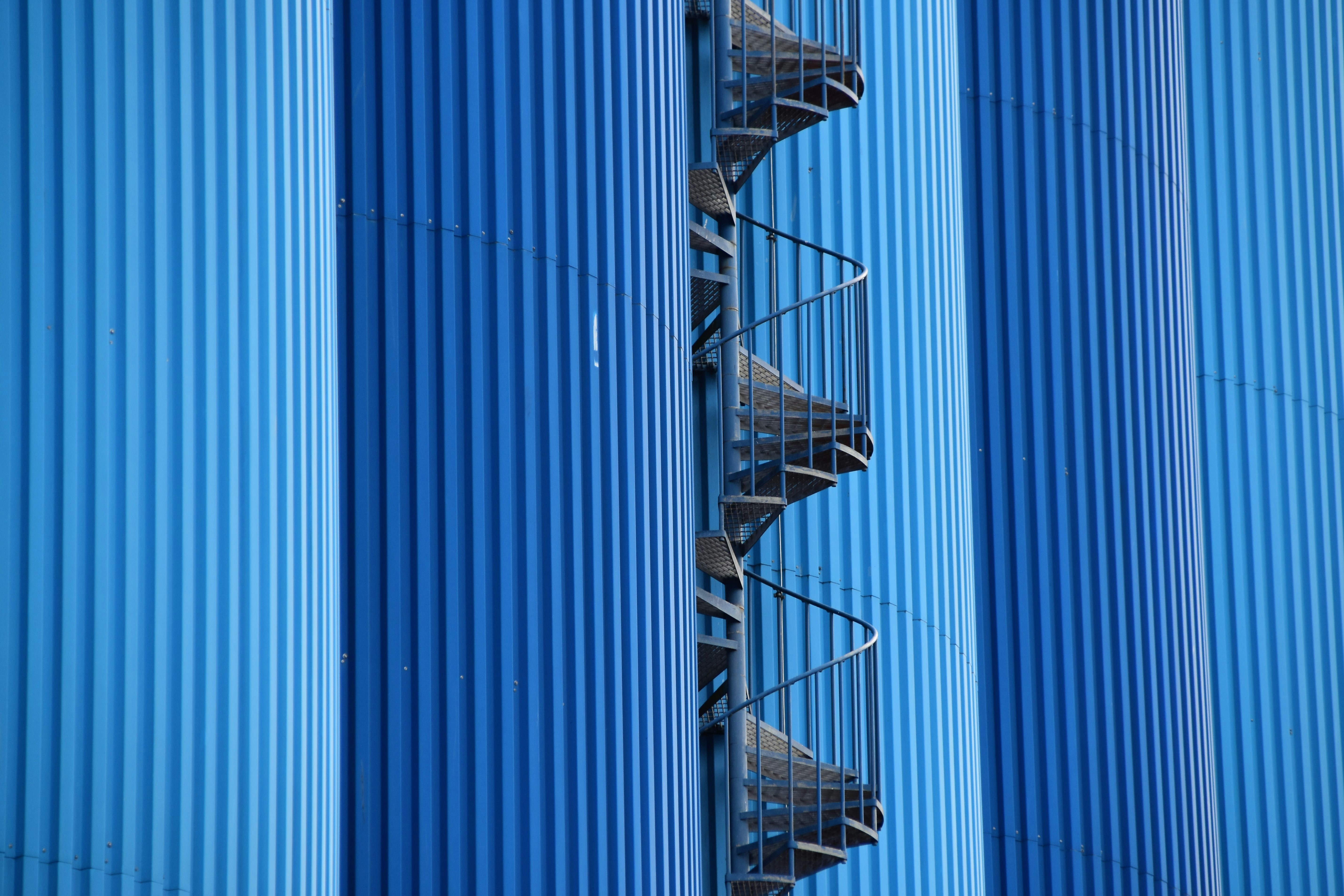 A tall blue building with a spiral staircase photo – Free Blue Image on ...