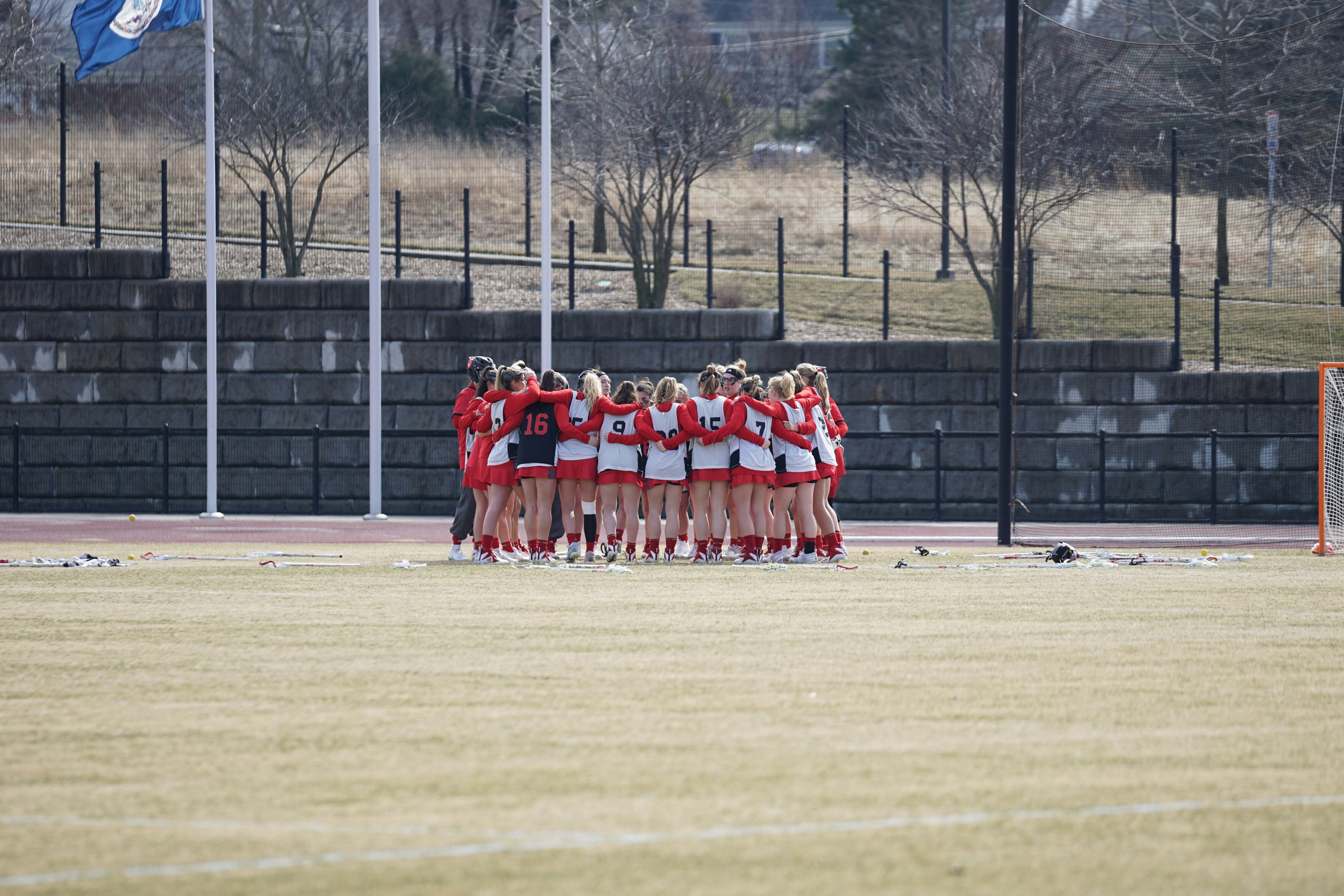 Red Jersey Convergence: A Team Huddle on a Quiet Field