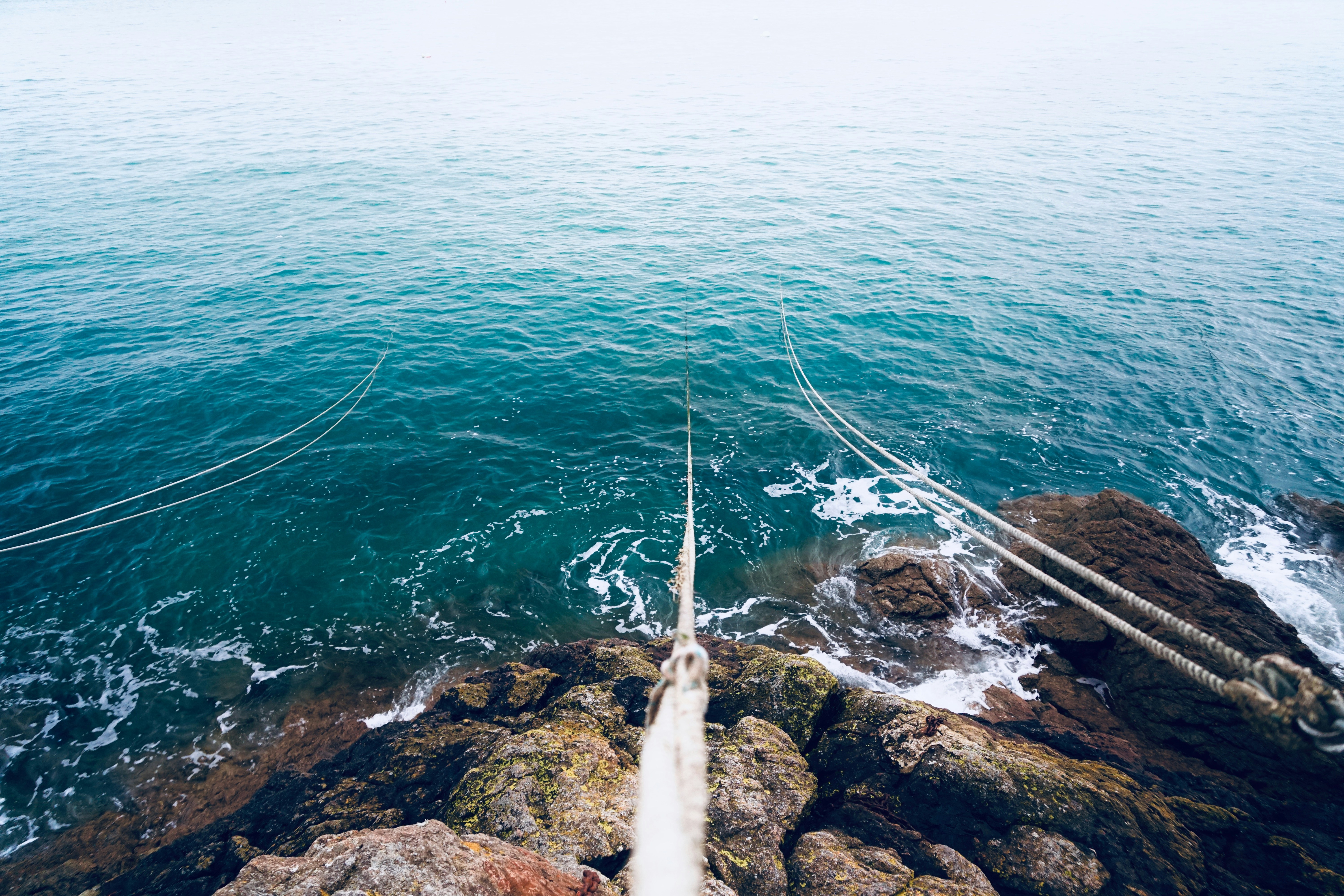 Rope Bridge Over Turquoise Waves: A Cliffside Descent