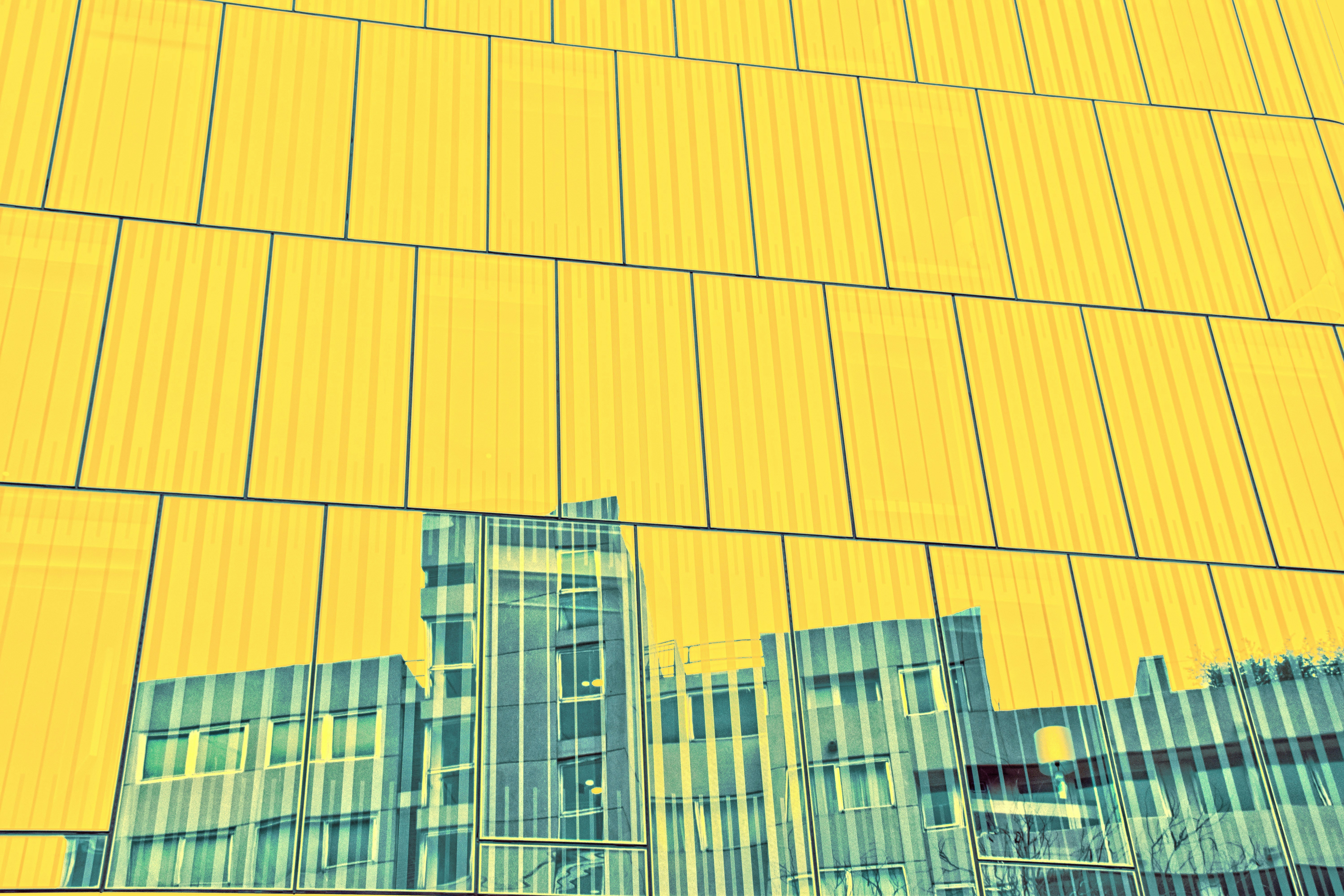 Luminous Grid Over a Blue Skyline: Reflections in a Modern Glass Facade