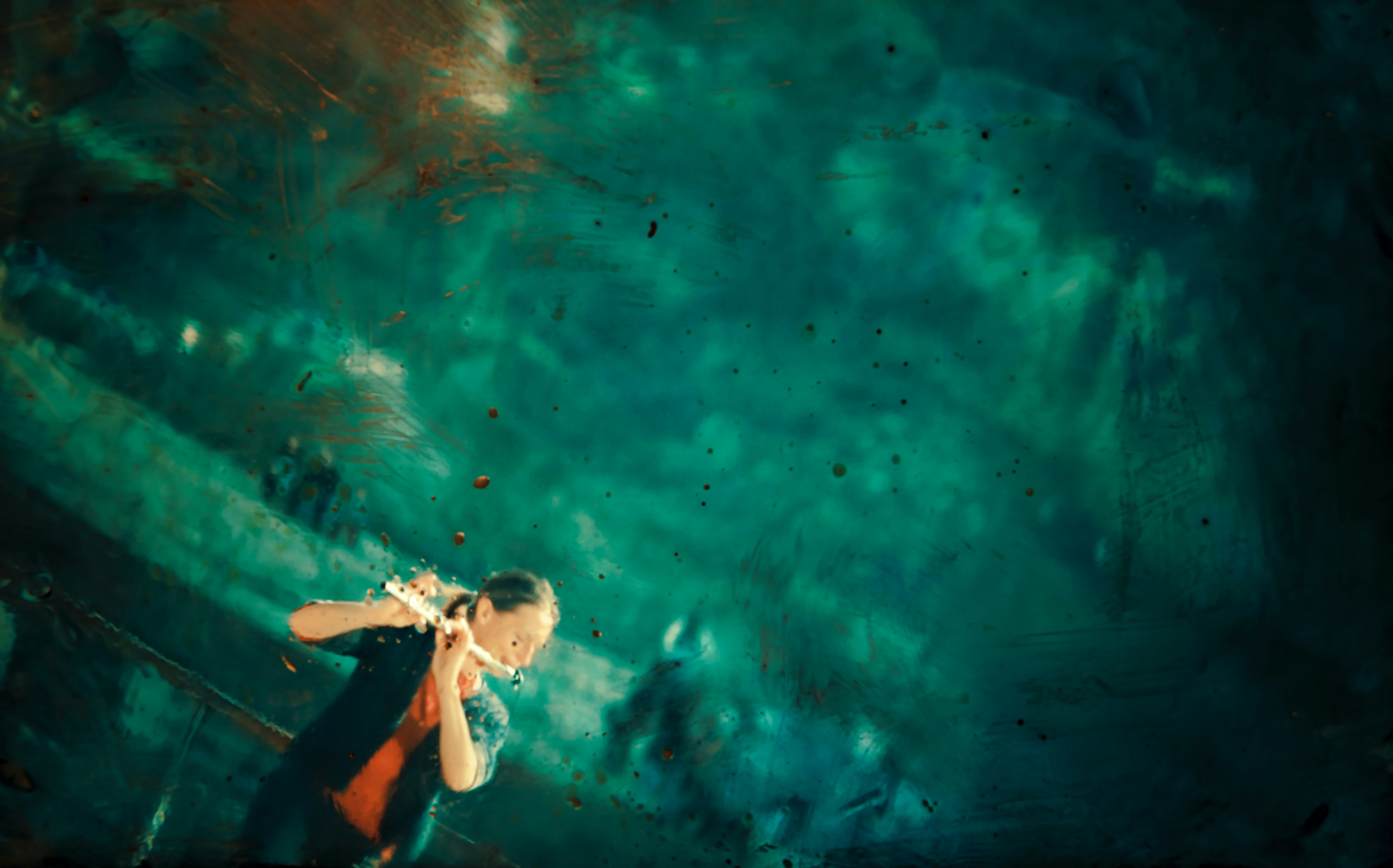 Flute player immersed in a dreamy, teal-toned backdrop.