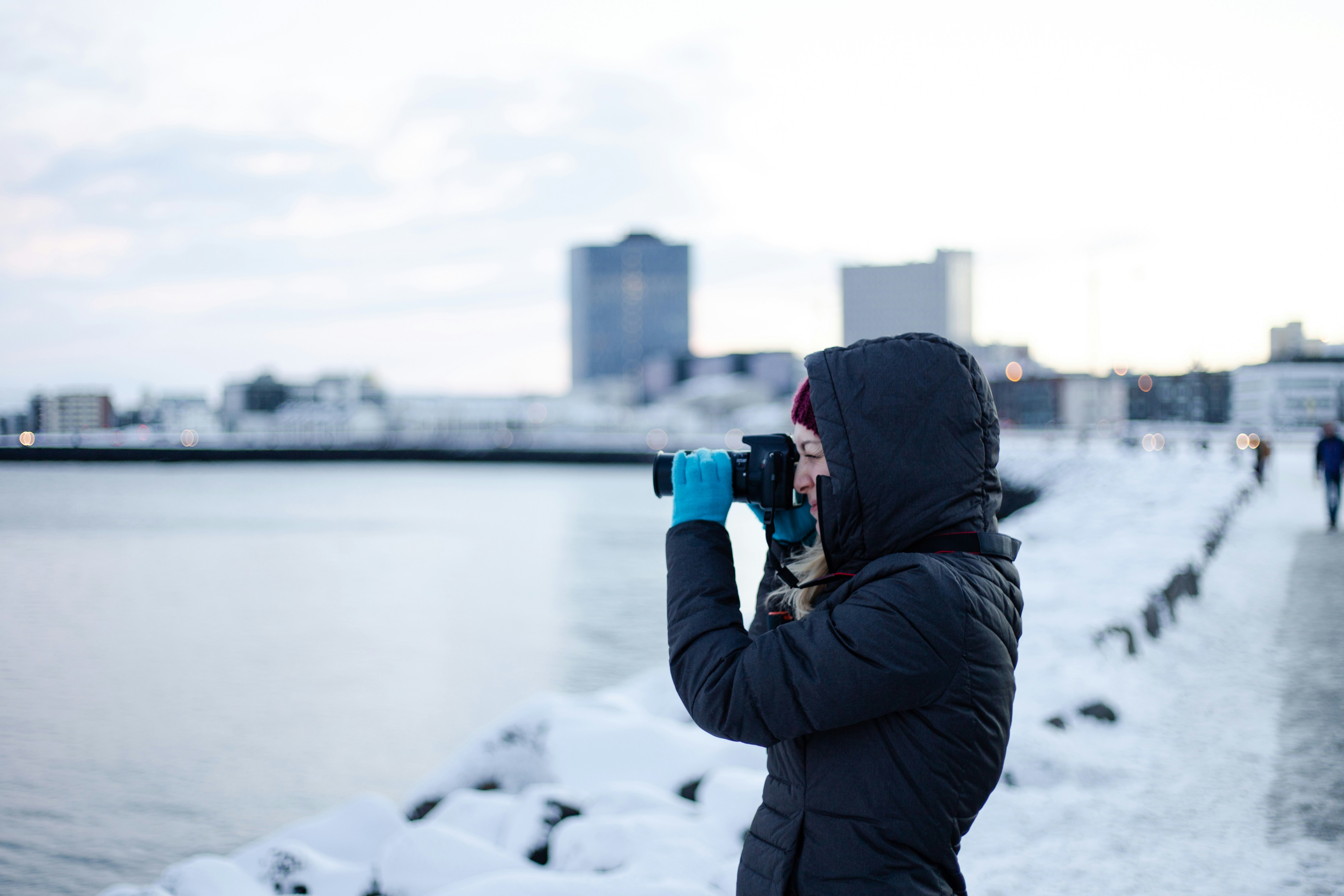 Foto Mujer con chaqueta negra con capucha usando cámara DSLR – Imagen ...