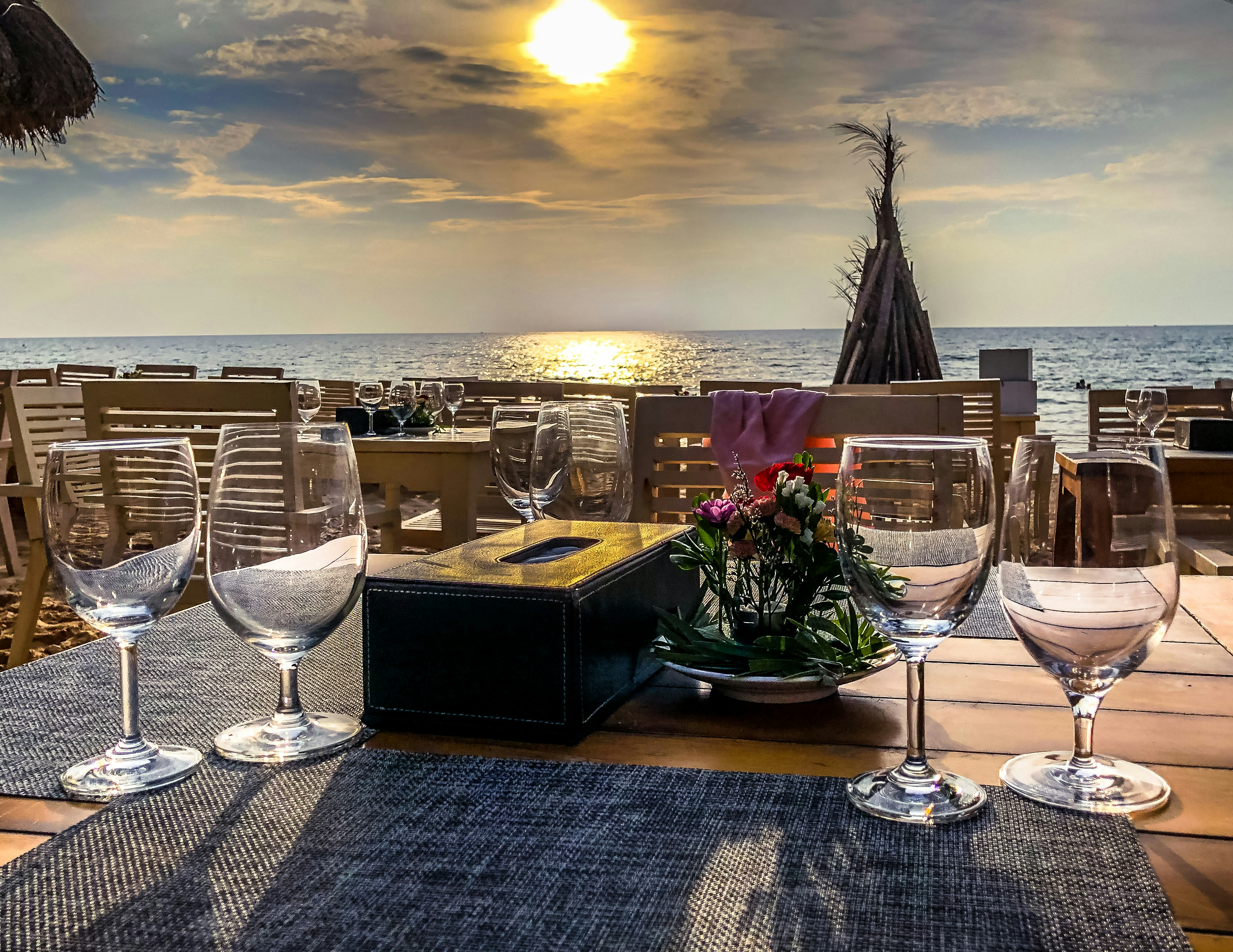 Sunset Serenade at a Seaside Table: Glassware, Flowers, and a Quiet Horizon