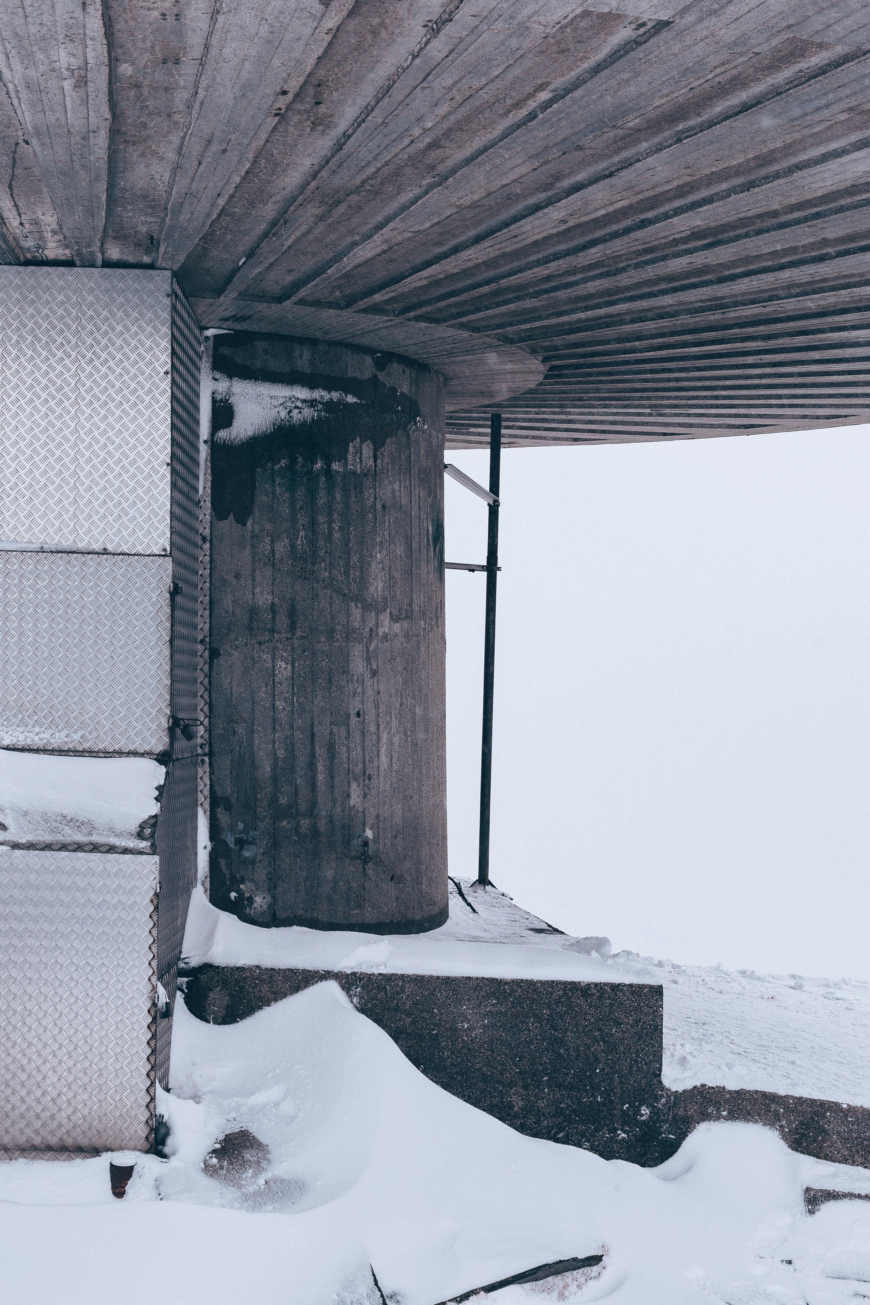 Radial Silence: Snow-Clad Concrete and Diamond Plate Under a Circular Canopy