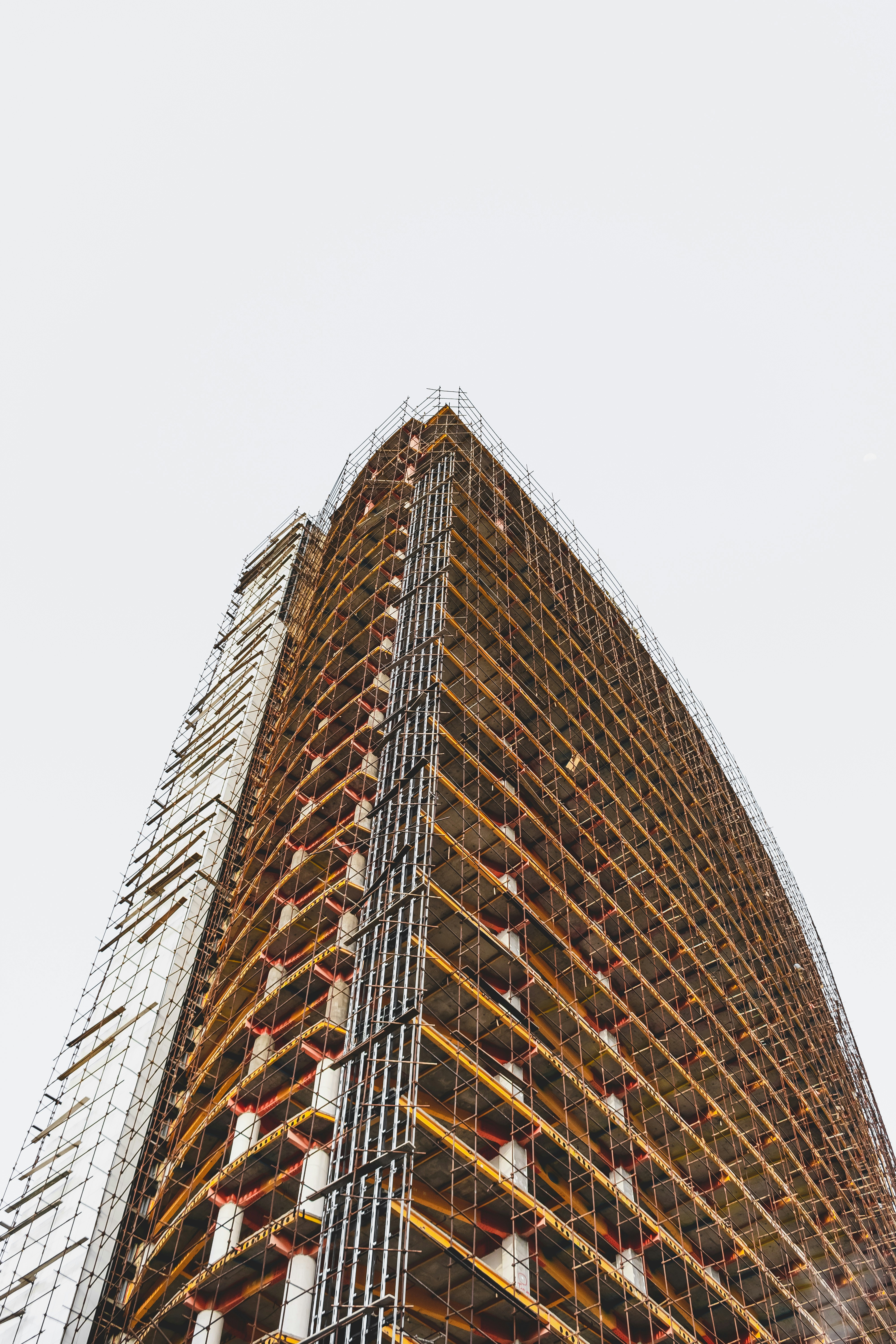 Rising Spine: A Curved High-Rise Wrapped in Orange Scaffolding