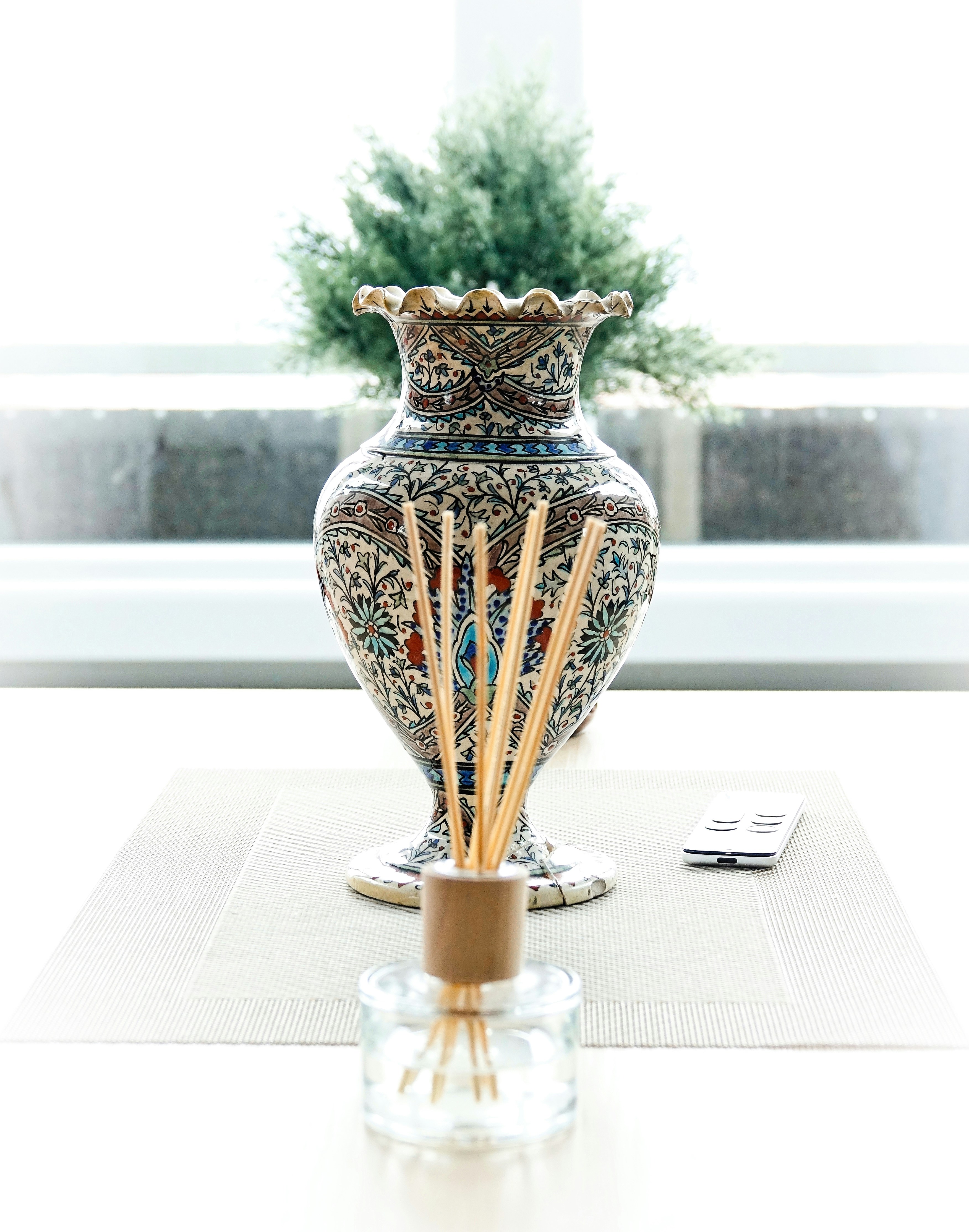 Ornate Persian vase with intricate patterns, placed in a modern interior with a diffused light background.