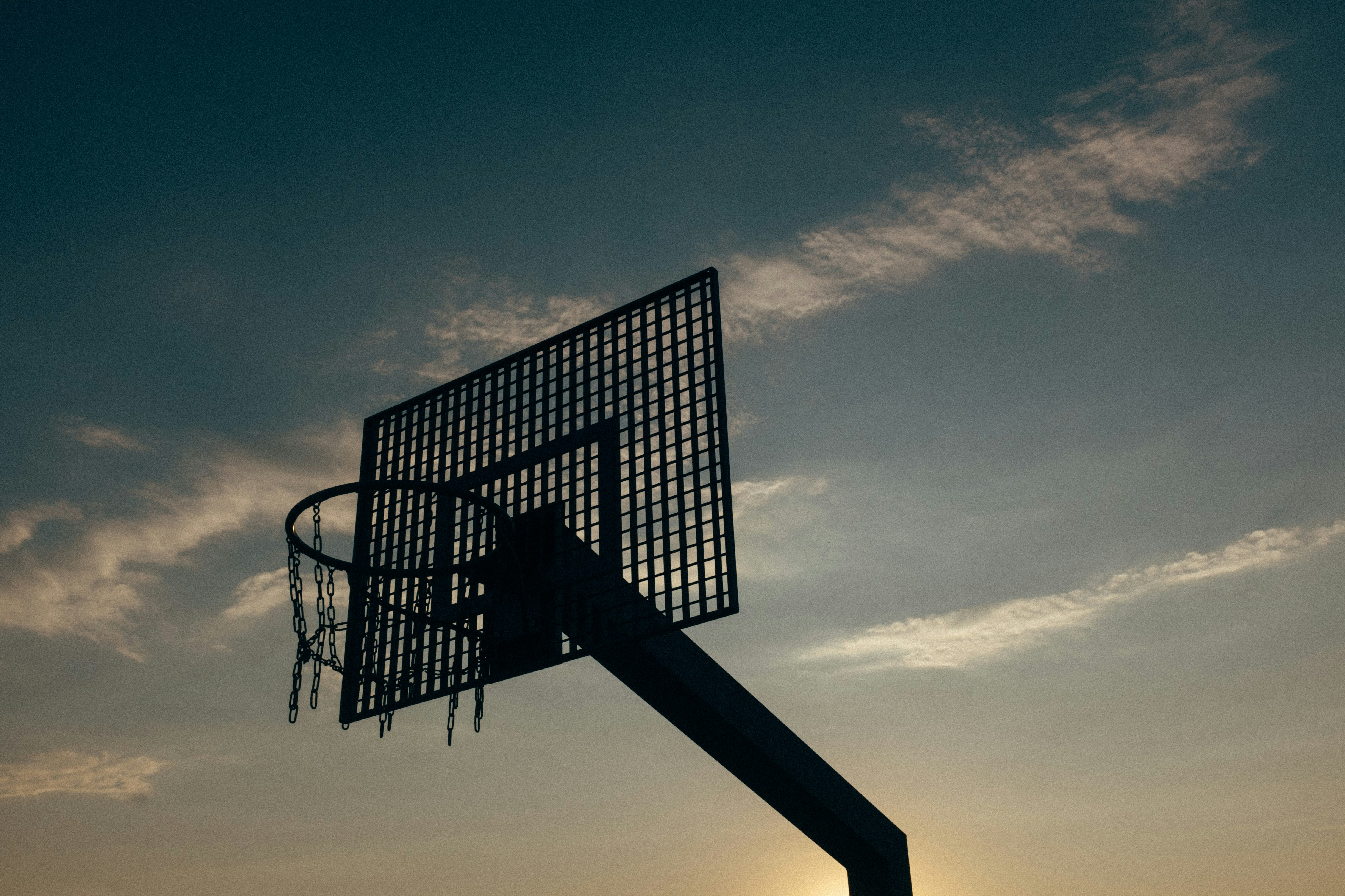 Basketball Hoop at Dusk: Silhouette Against a Quiet Sky