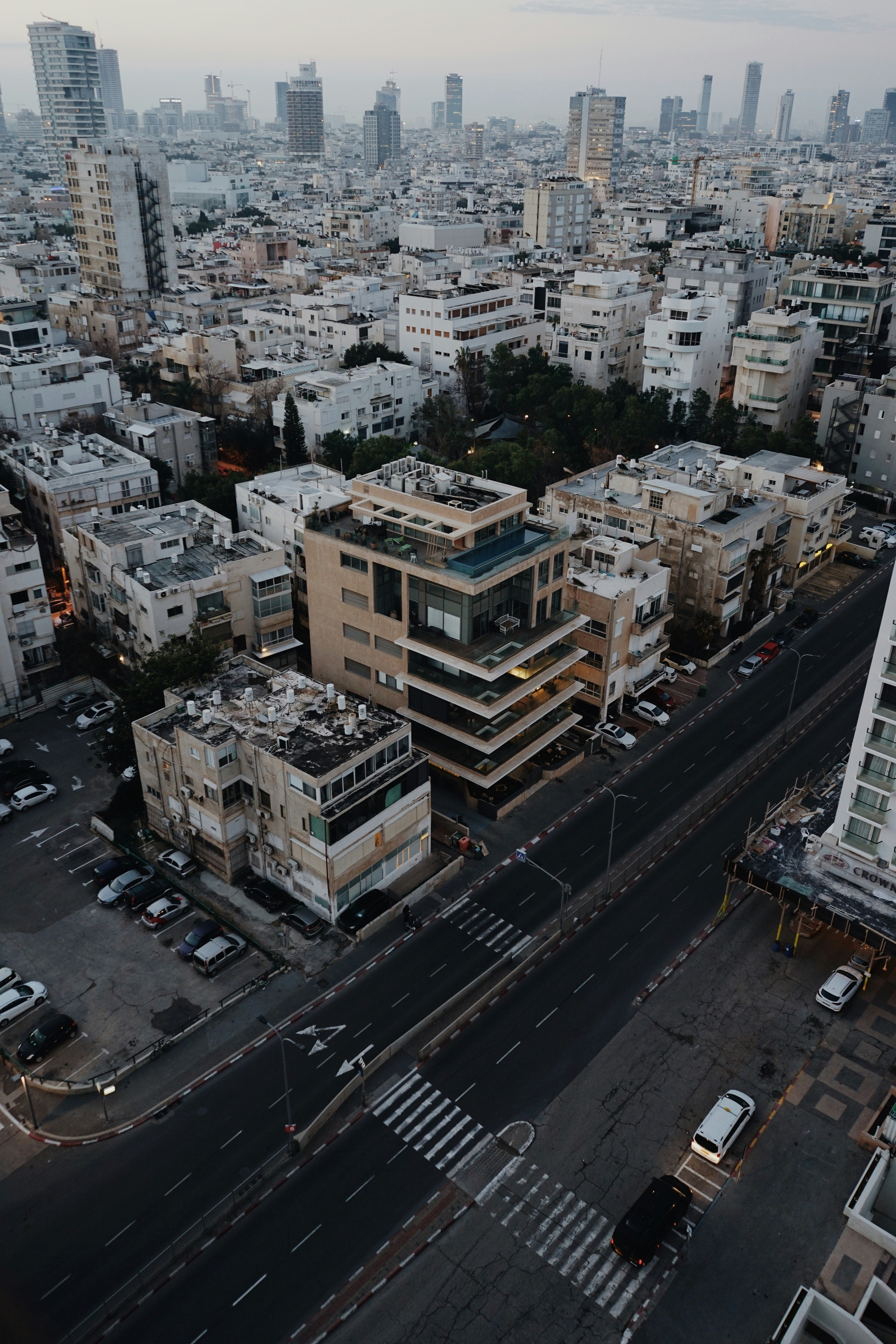 Aerial view of a bustling urban landscape showcasing a mix of modern and traditional architecture, with a focus on a prominent building amid the city grid.