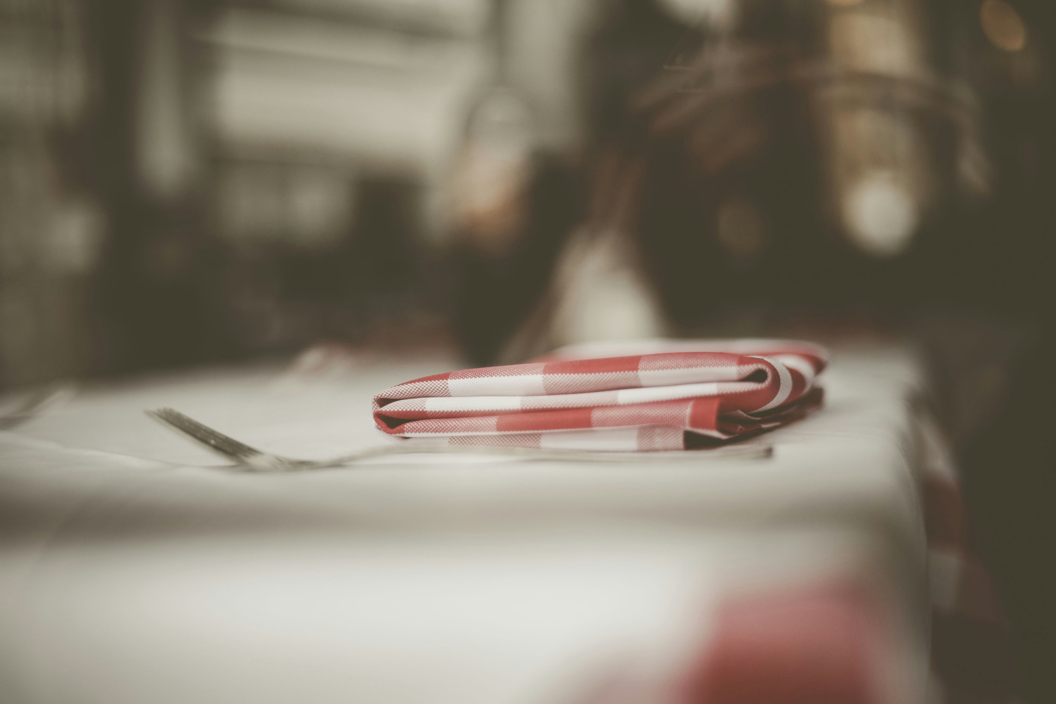 Red-and-white striped napkin on a softly lit table edge