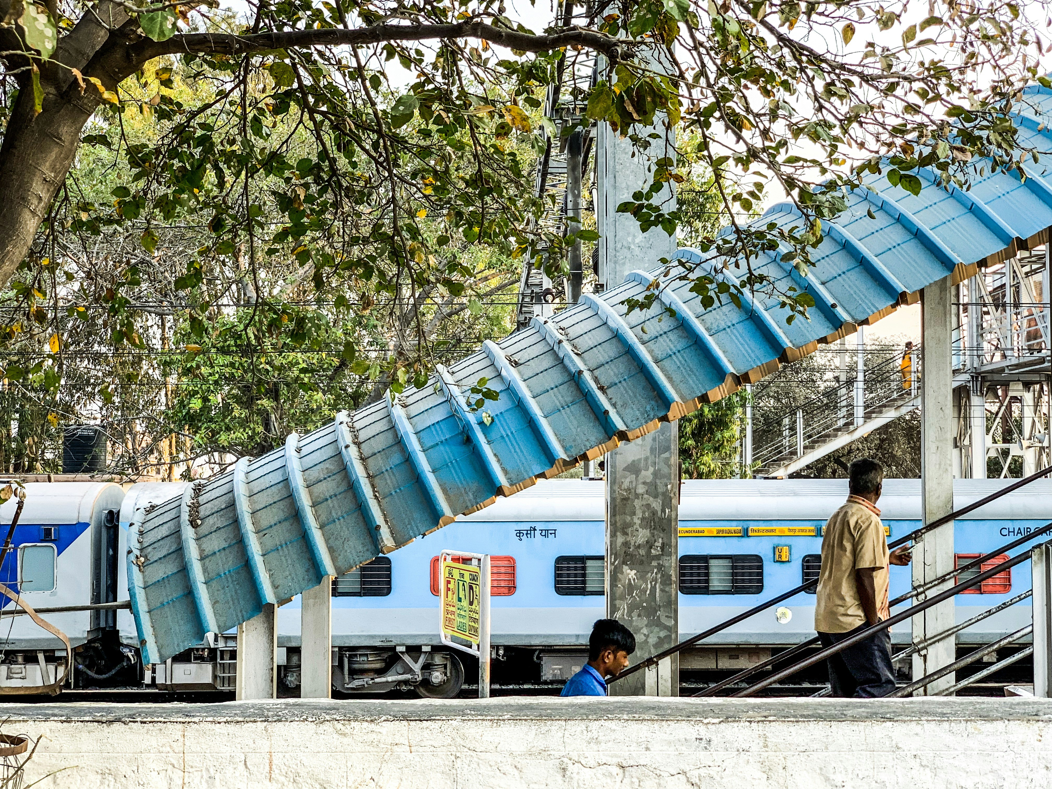 Blue Archway Over Rails: A Quiet Moment on the Platform