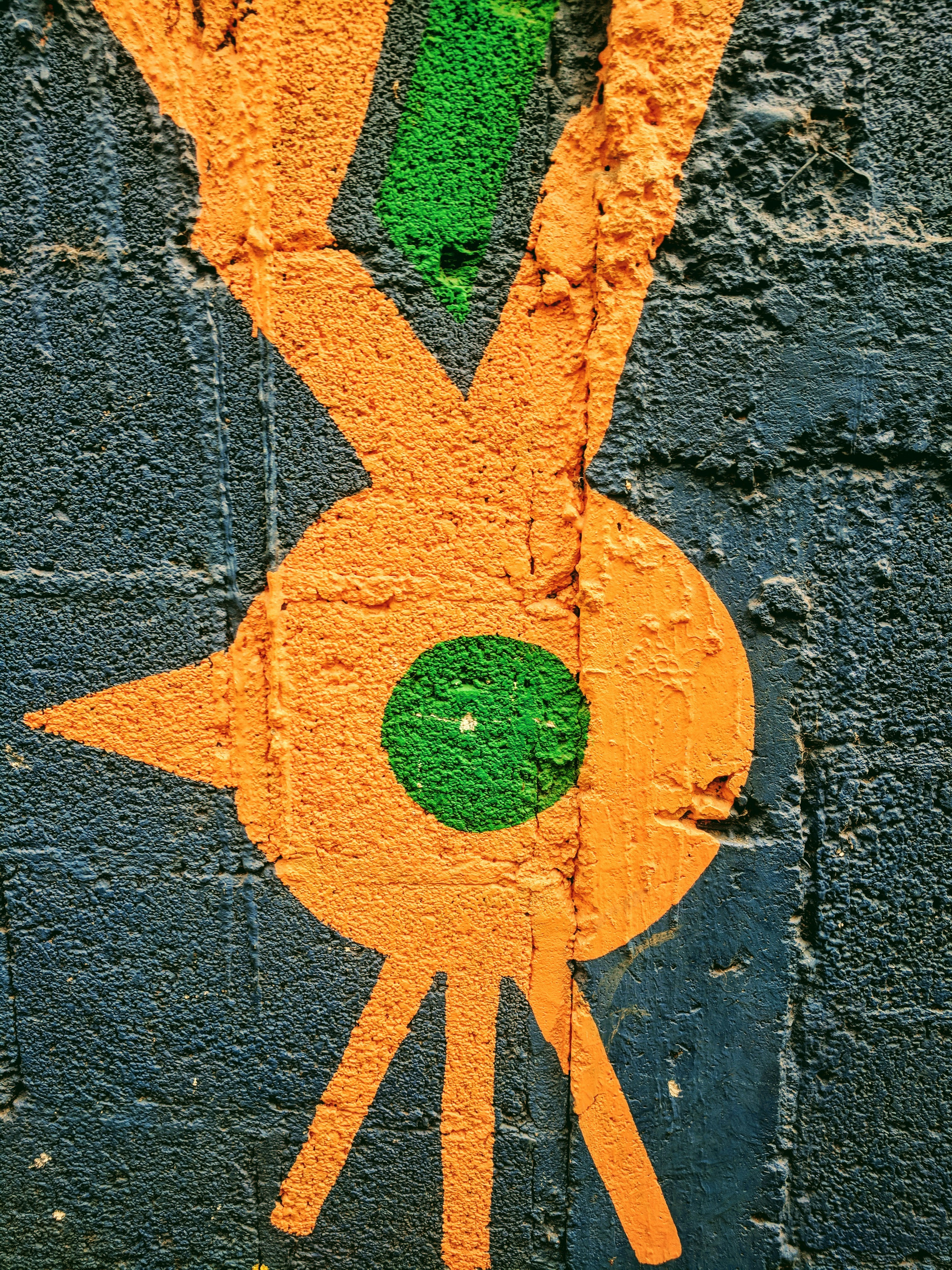 Colorful abstract bird mural featuring orange and green tones against a textured blue background.