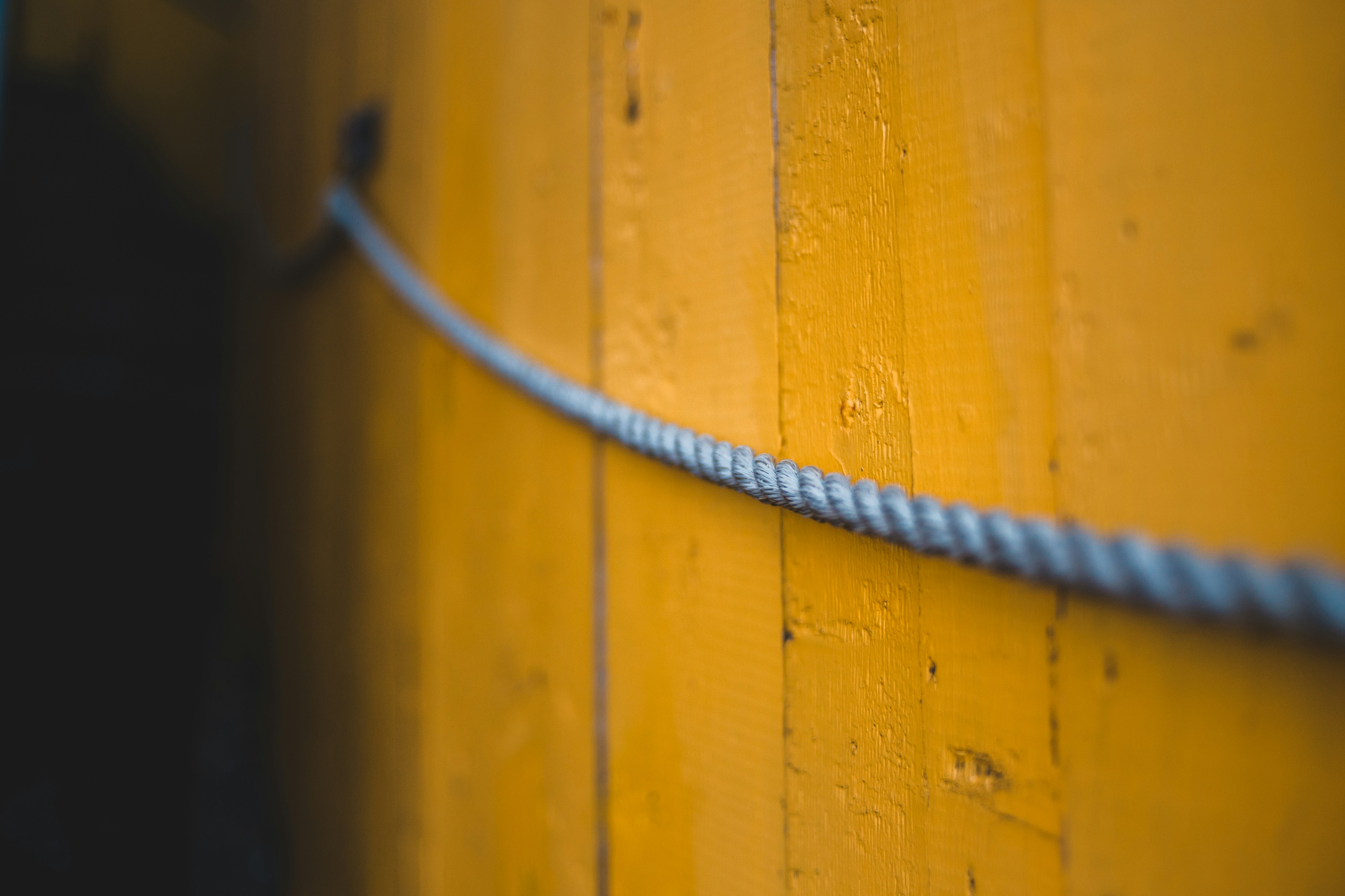 gray rope on yellow painted wooden wall