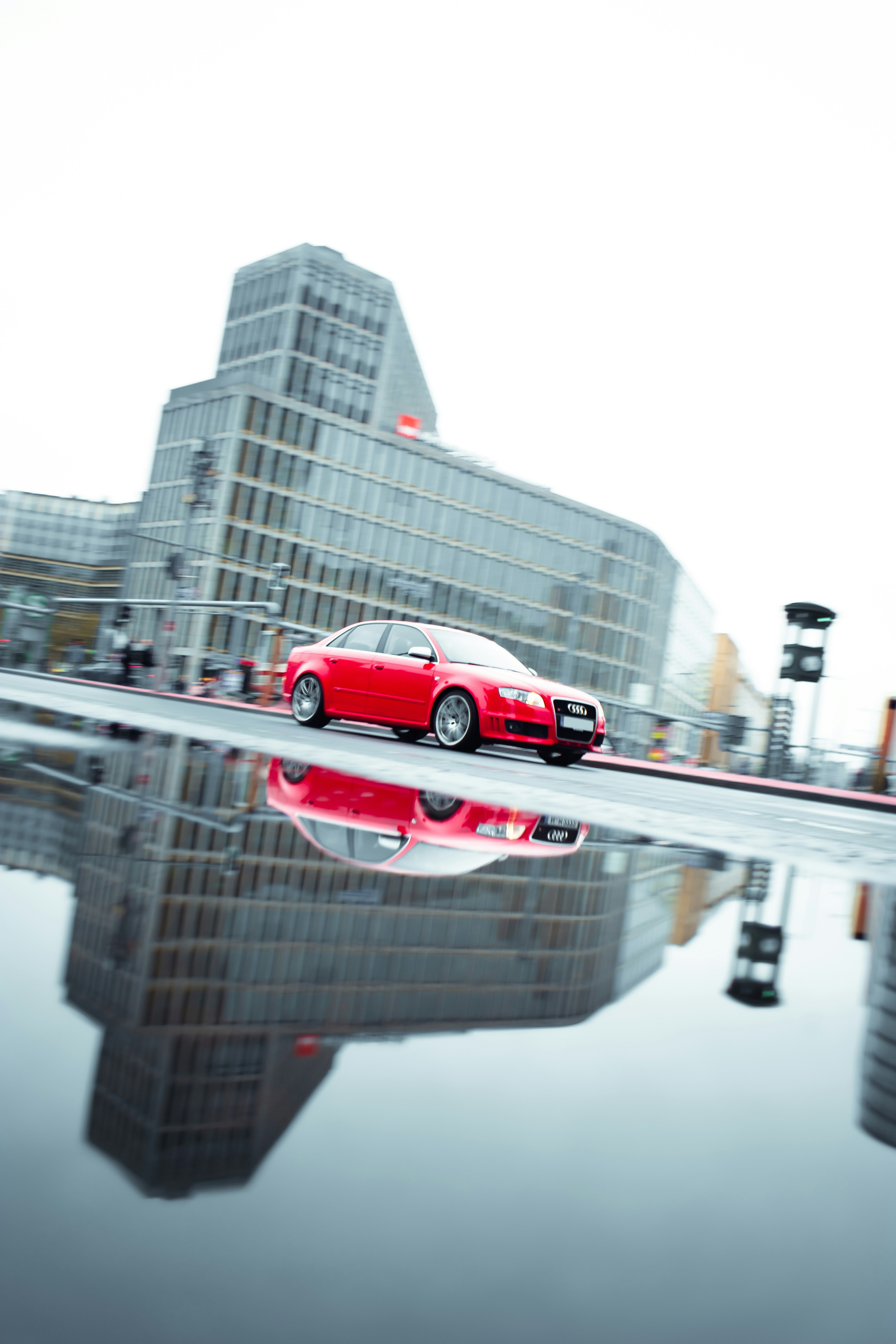 Red Audi on a Sky-Reflected City Run