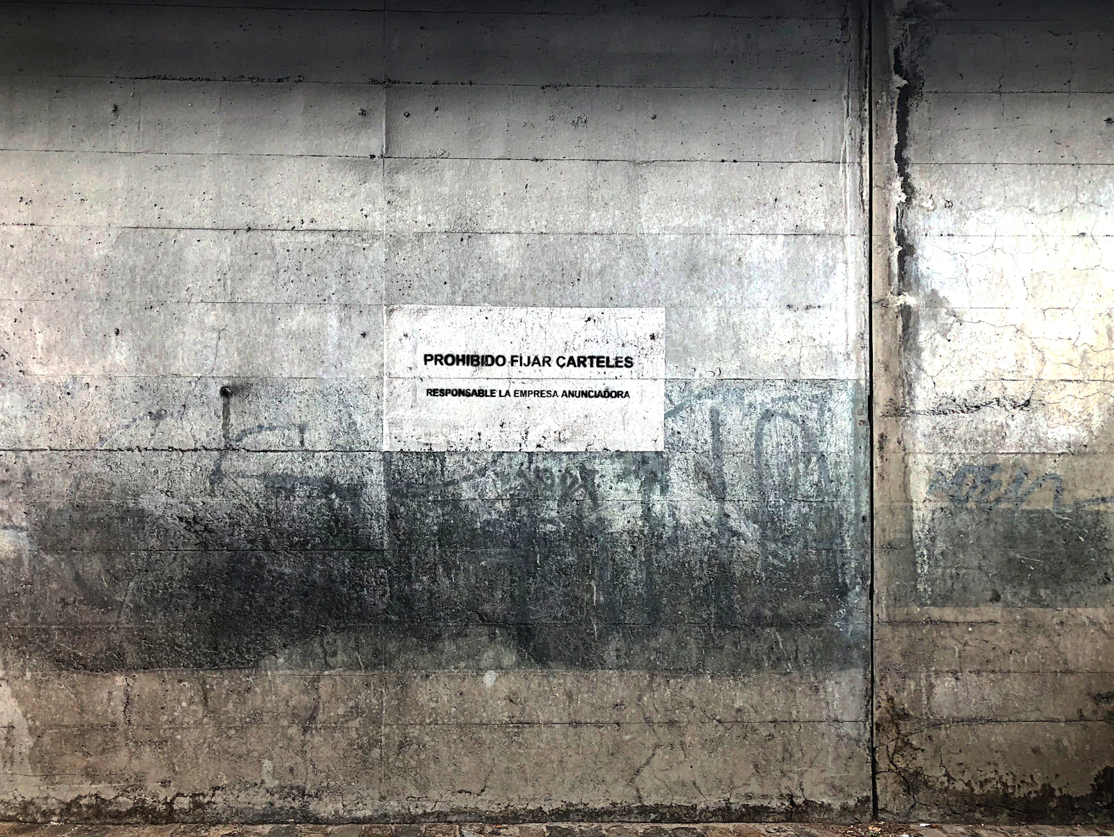 Weathered Concrete Wall with Graffiti and Sign