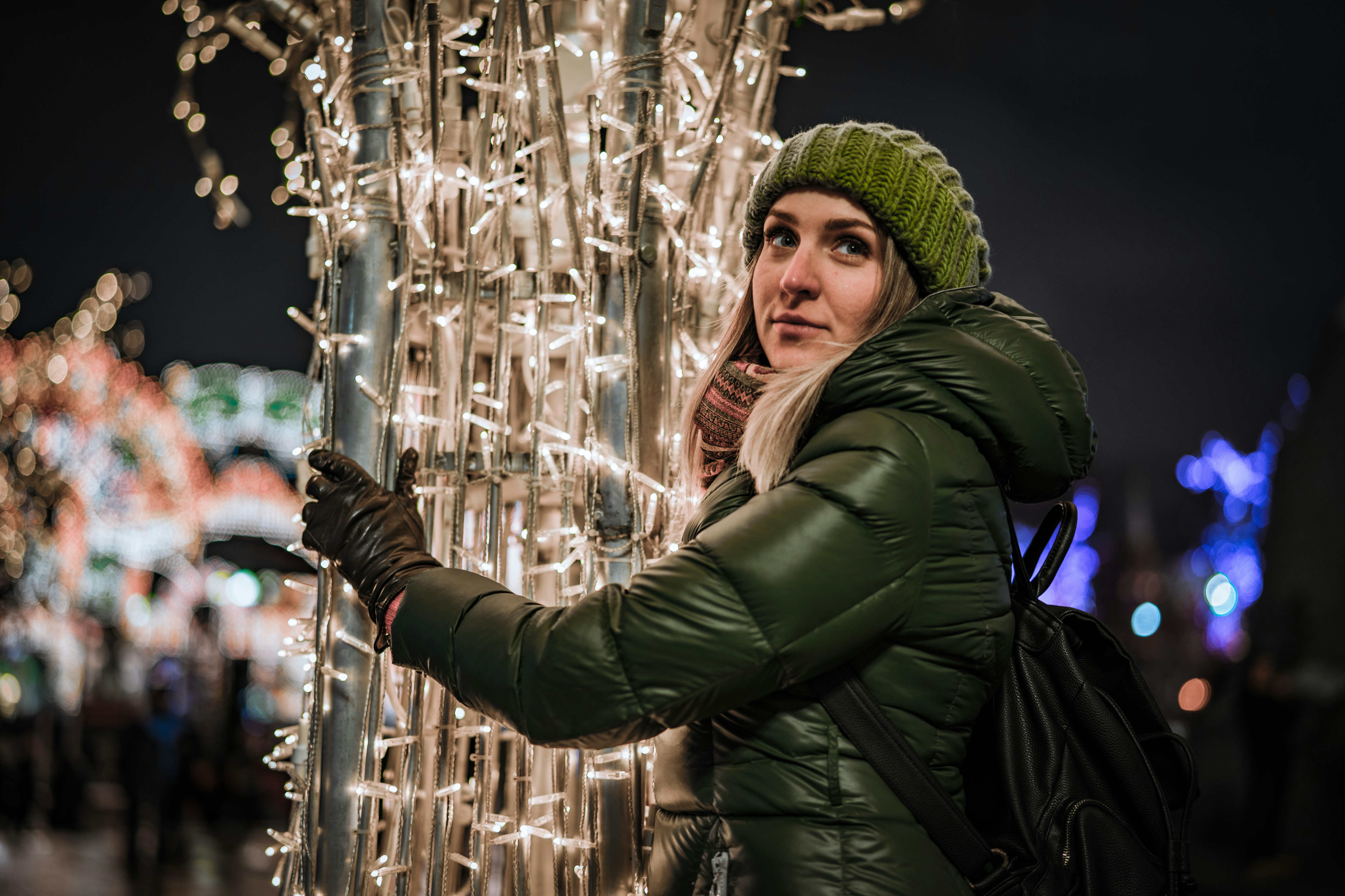 Foto Mujer con chaqueta de burbujas abrazando un poste cubierto de LED ...