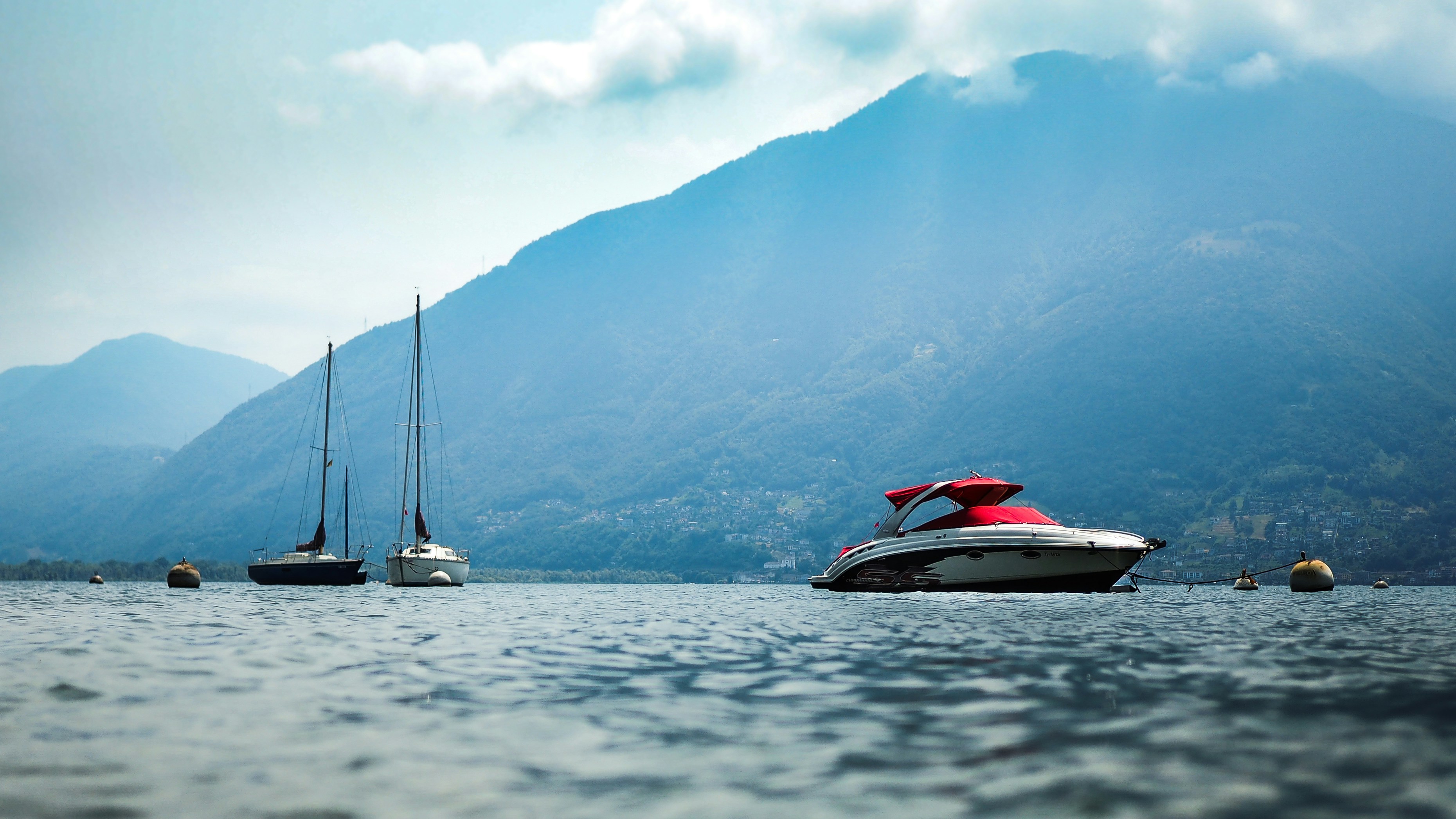 Crimson Runabout Slicing Through Mist on a Mountain Lake